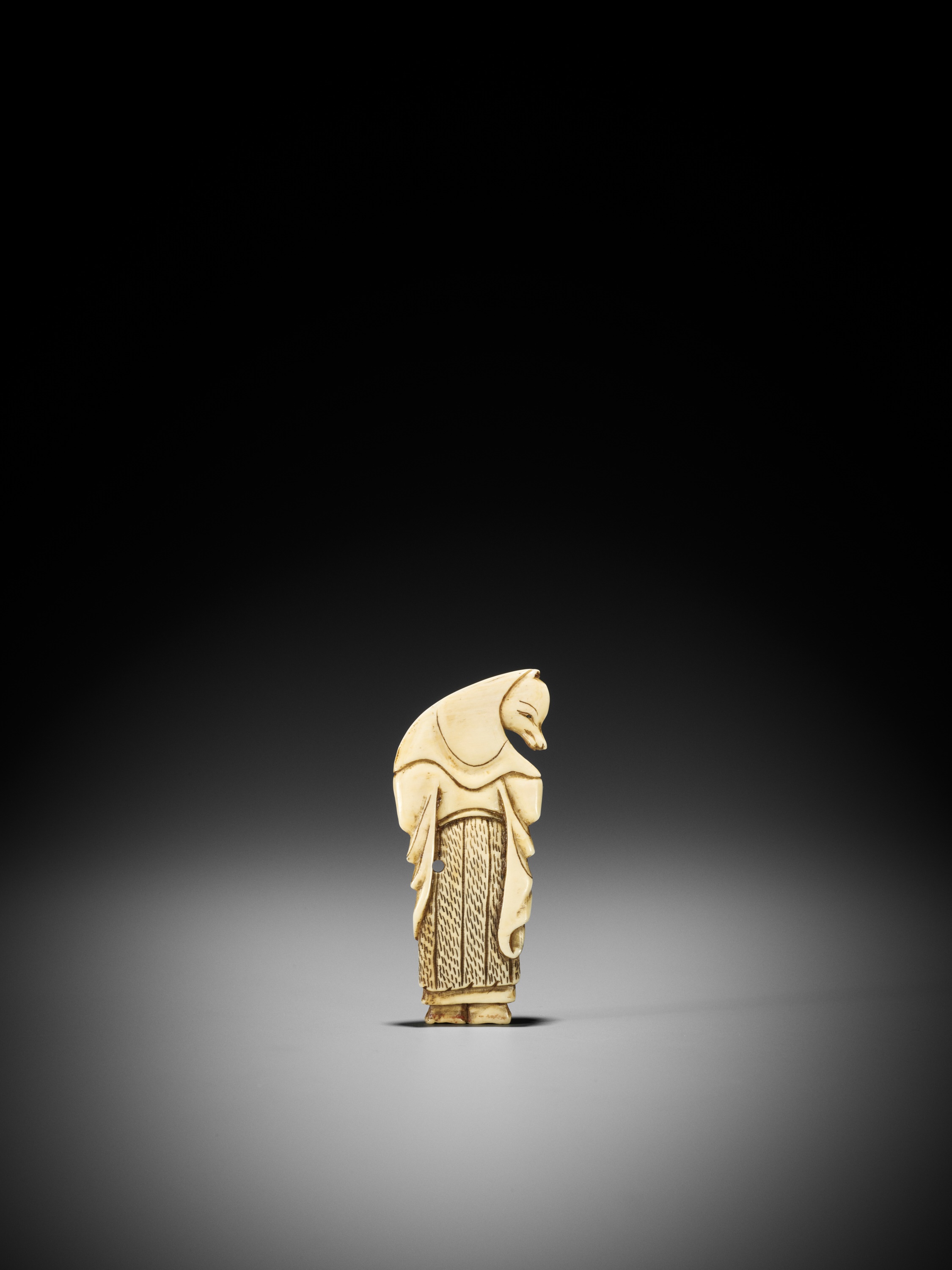 Lot 182 - A FLAT IVORY NETSUKE OF A FOX PRIEST