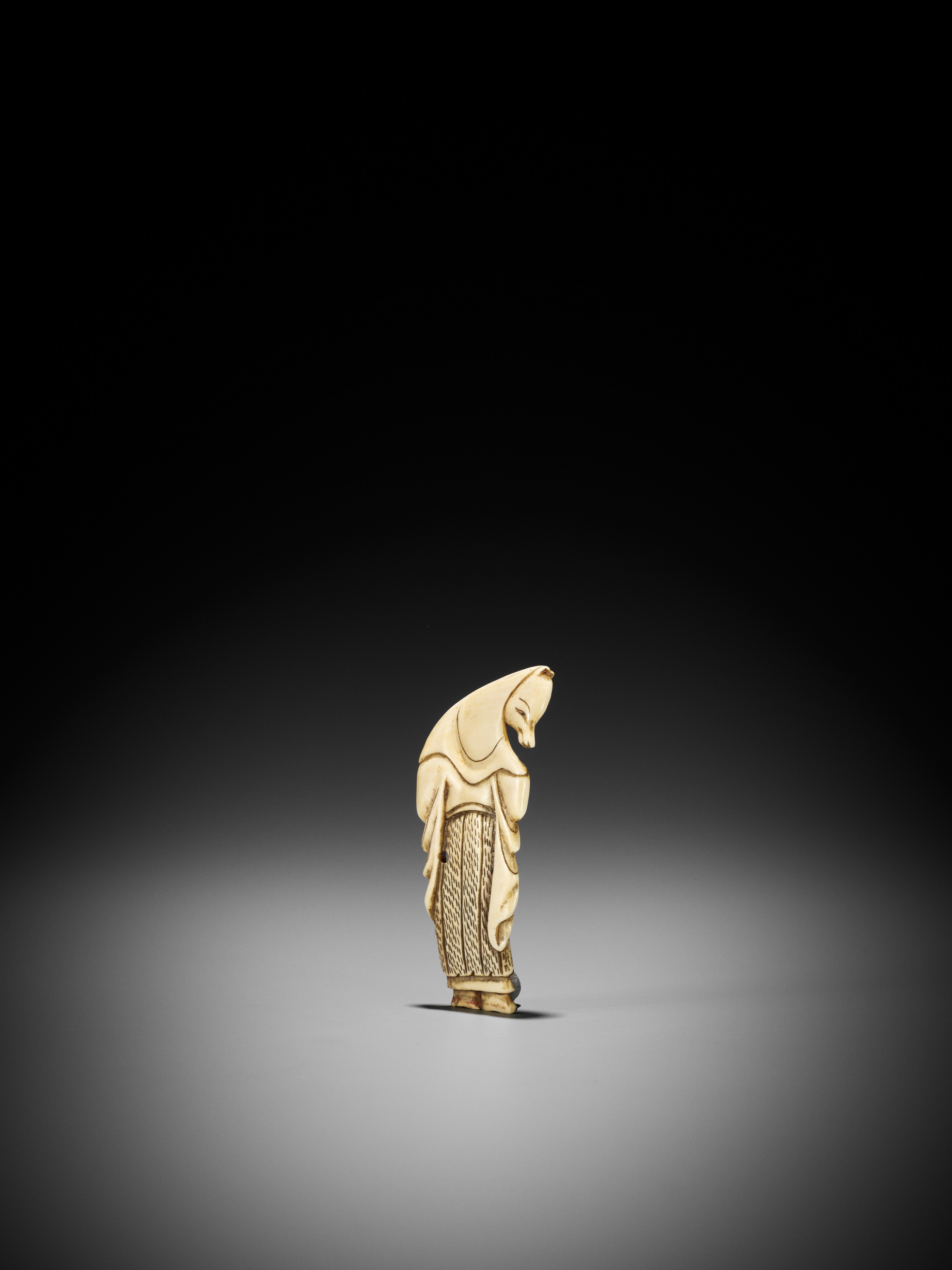 Lot 182 - A FLAT IVORY NETSUKE OF A FOX PRIEST