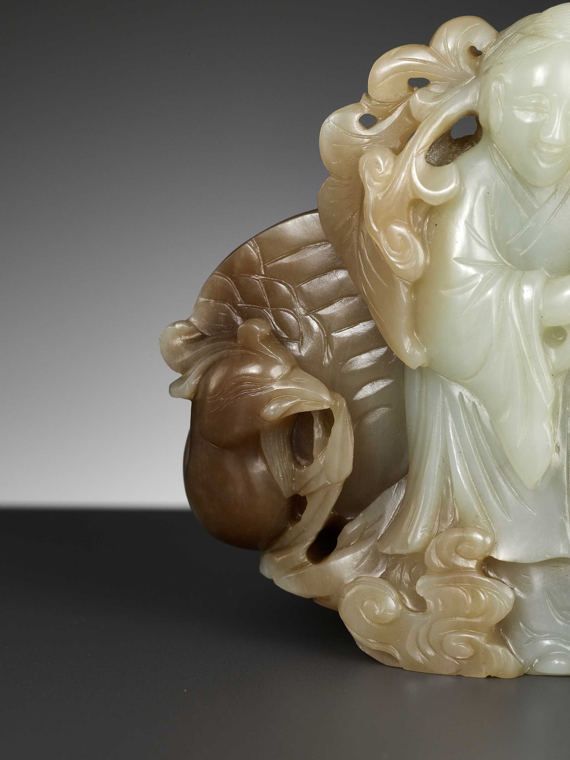 Lot 353 - A CELADON AND BROWN JADE ‘HE XIANGU, BOY AND
