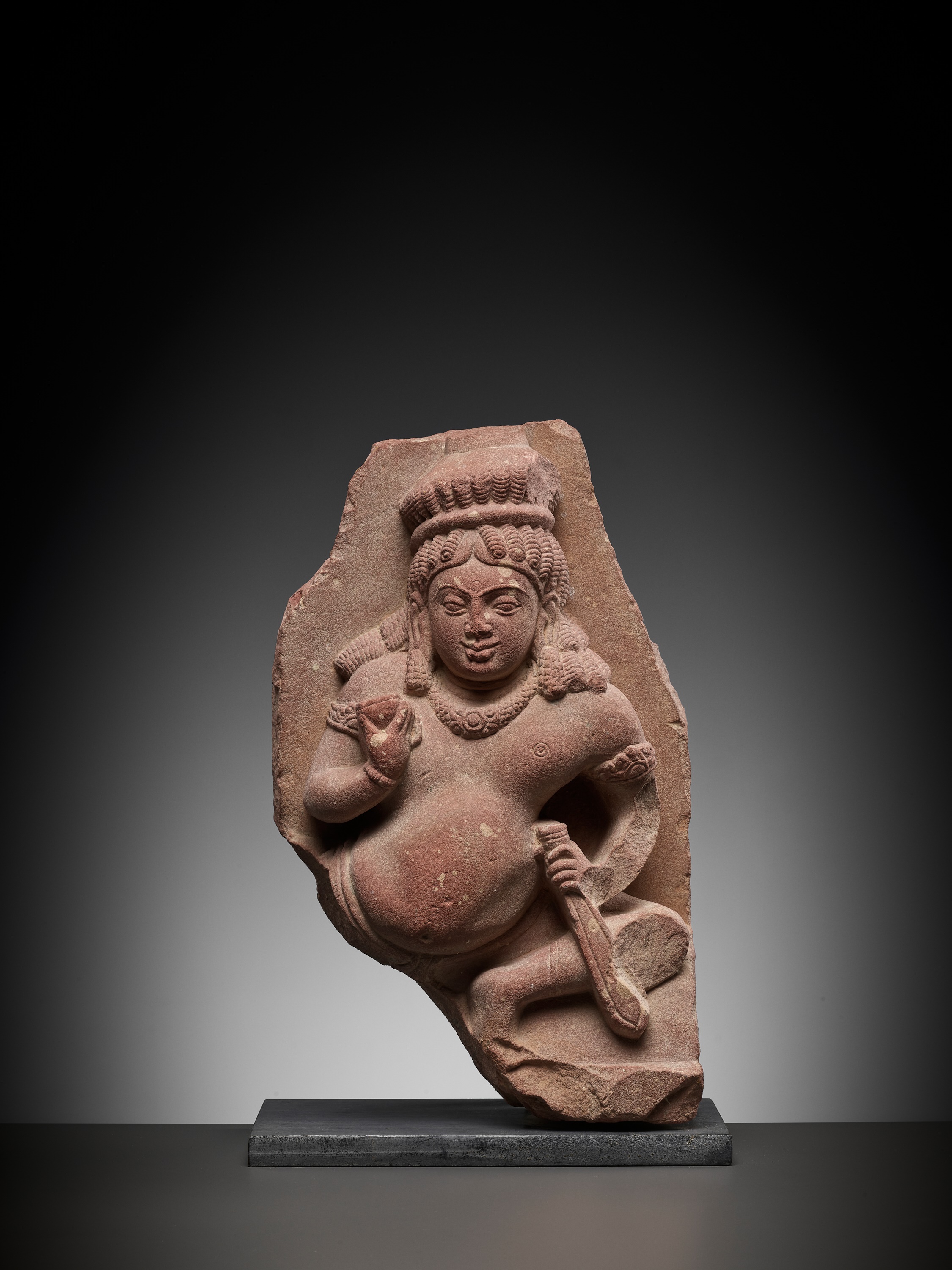 Lot 695 - A PINK SANDSTONE FIGURE OF KUBERA, MATHURA
