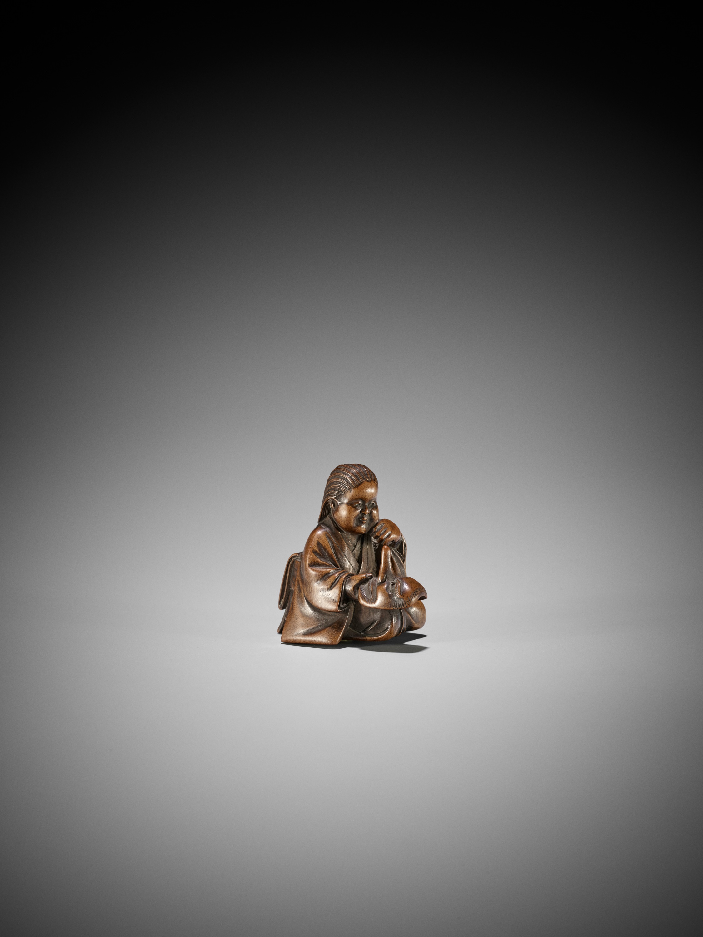Lot 254 - A FINE WOOD SHUNGA NETSUKE OF OKAME HOLDING