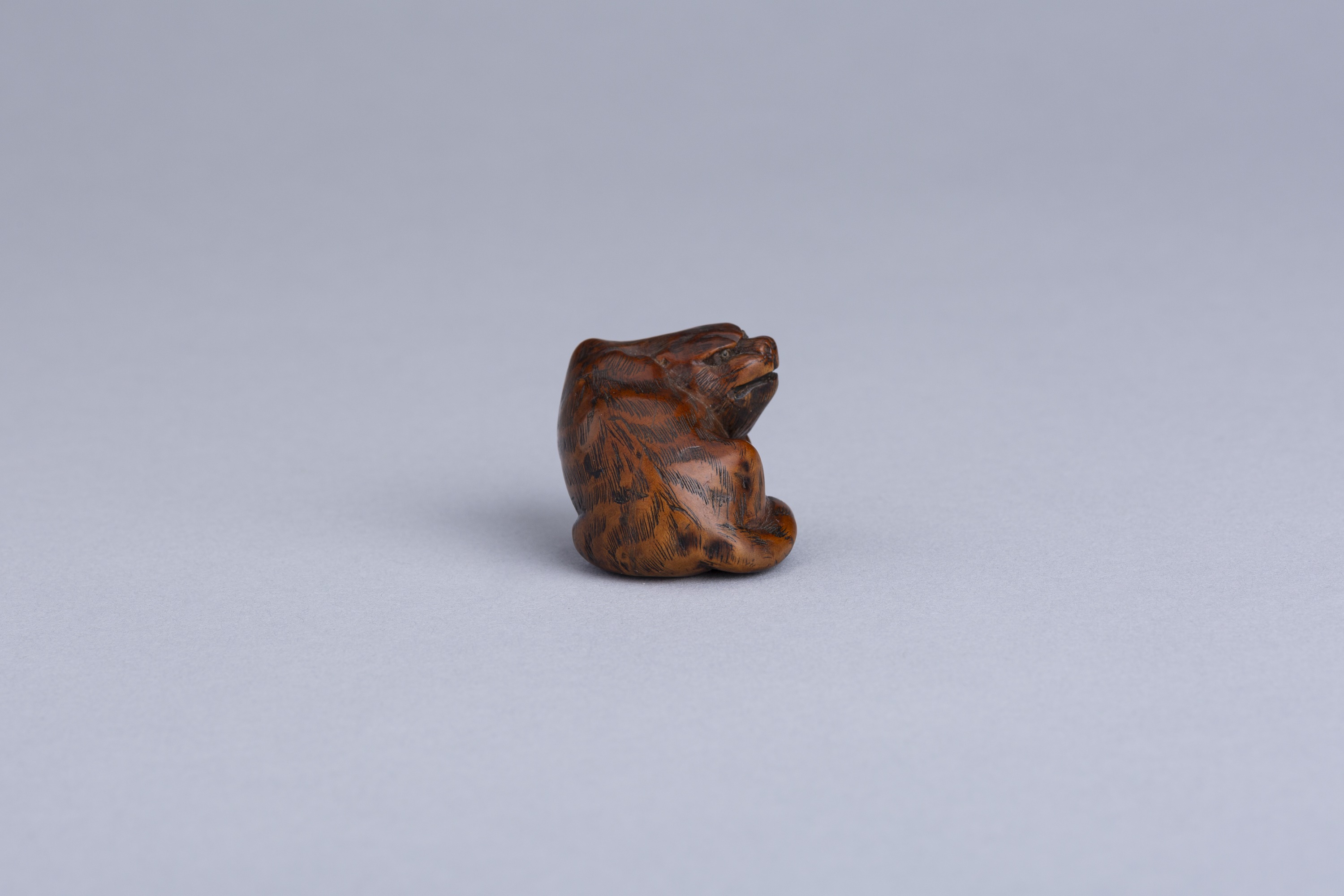 Lot 333 - MASANAO: A WOOD NETSUKE OF A SNARLING TIGER,