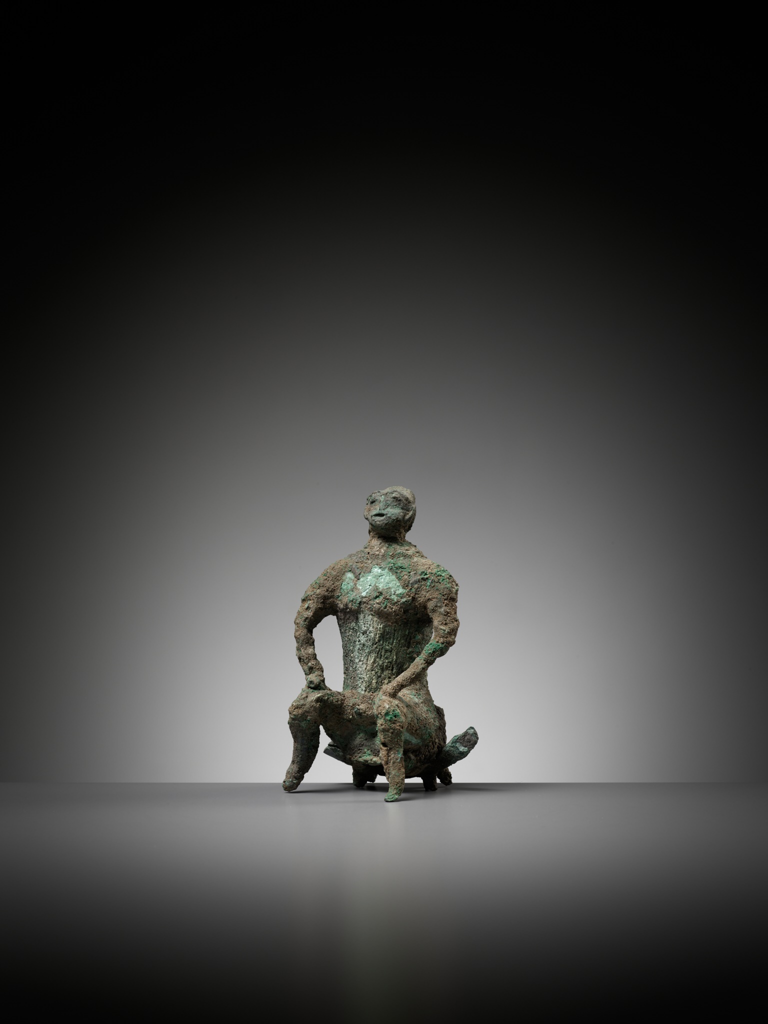 Lot 615 - A BRONZE FIGURE OF A SEATED MAN, DONG SON