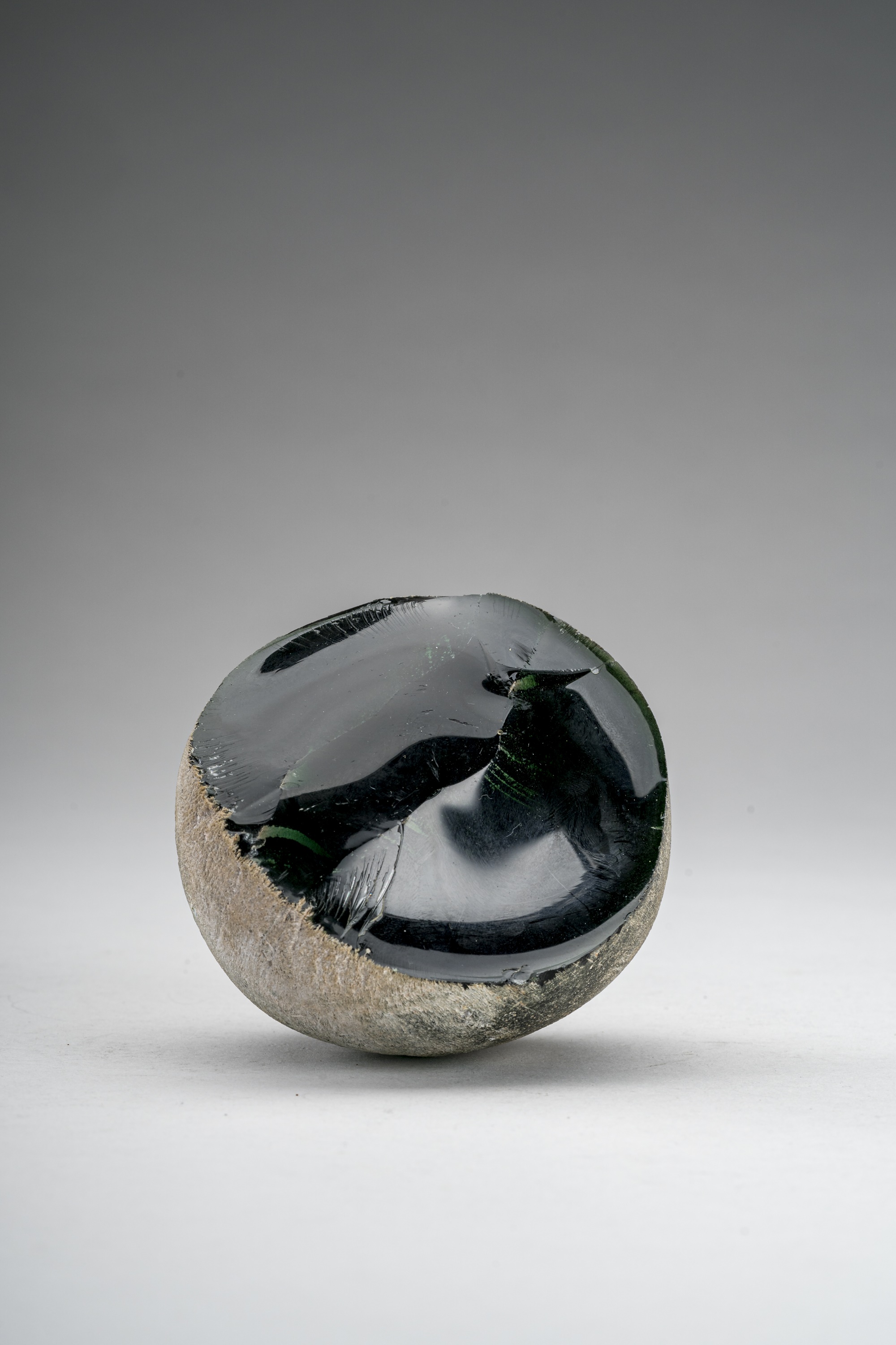 Lot 15 - A TRANSLUCENT GREEN GLASS ‘COSMIC EGG’, HAN