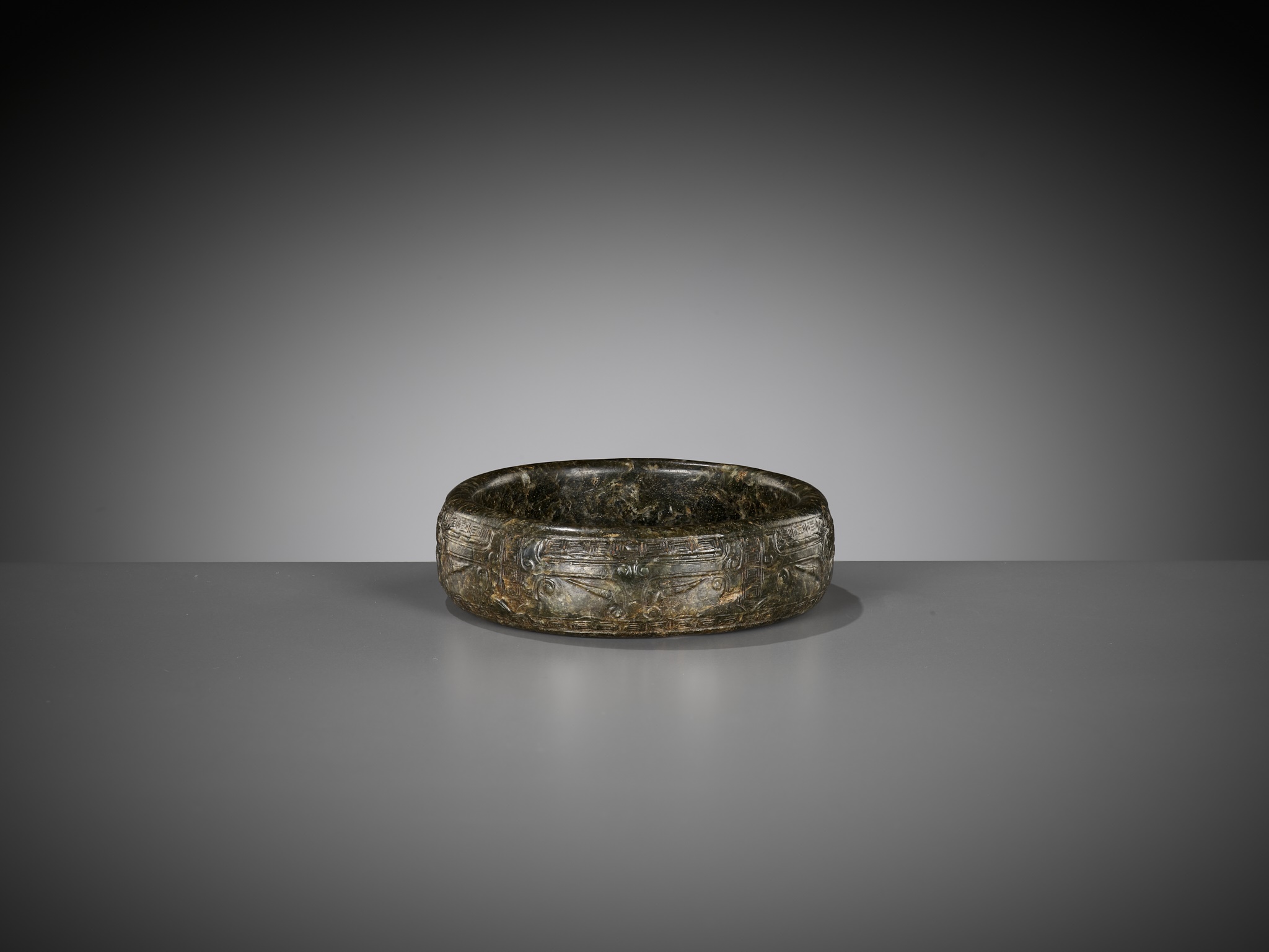 Lot 327 - AN ARCHAISTIC SPINACH-GREEN JADE ‘TAOTIE’