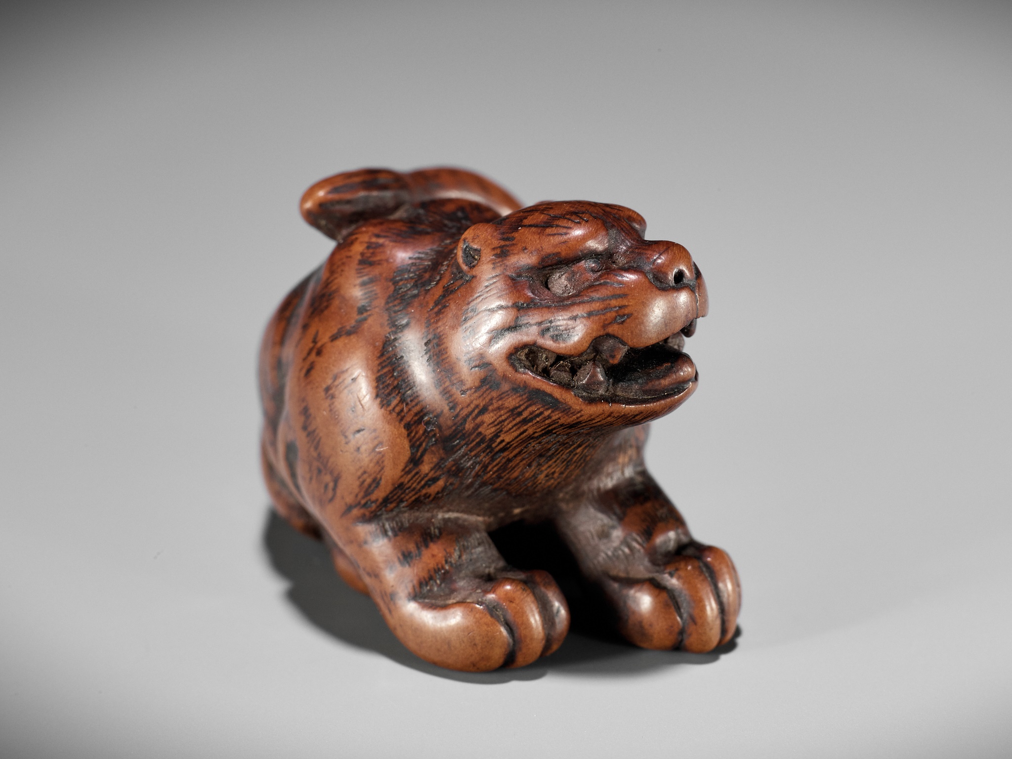 Lot 141 - KOKEI: A WOOD NETSUKE OF A TIGER