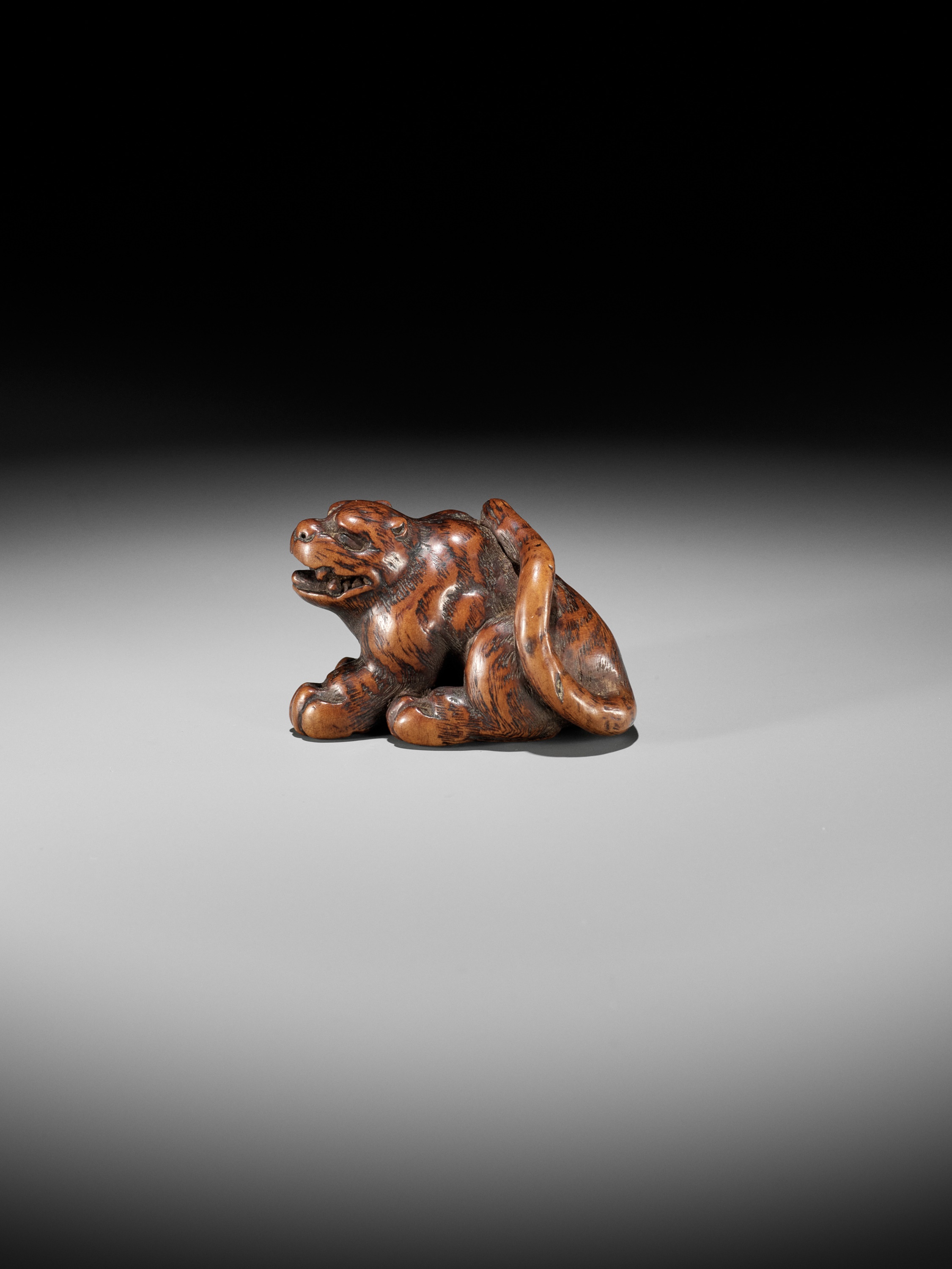 Lot 141 - KOKEI: A WOOD NETSUKE OF A TIGER