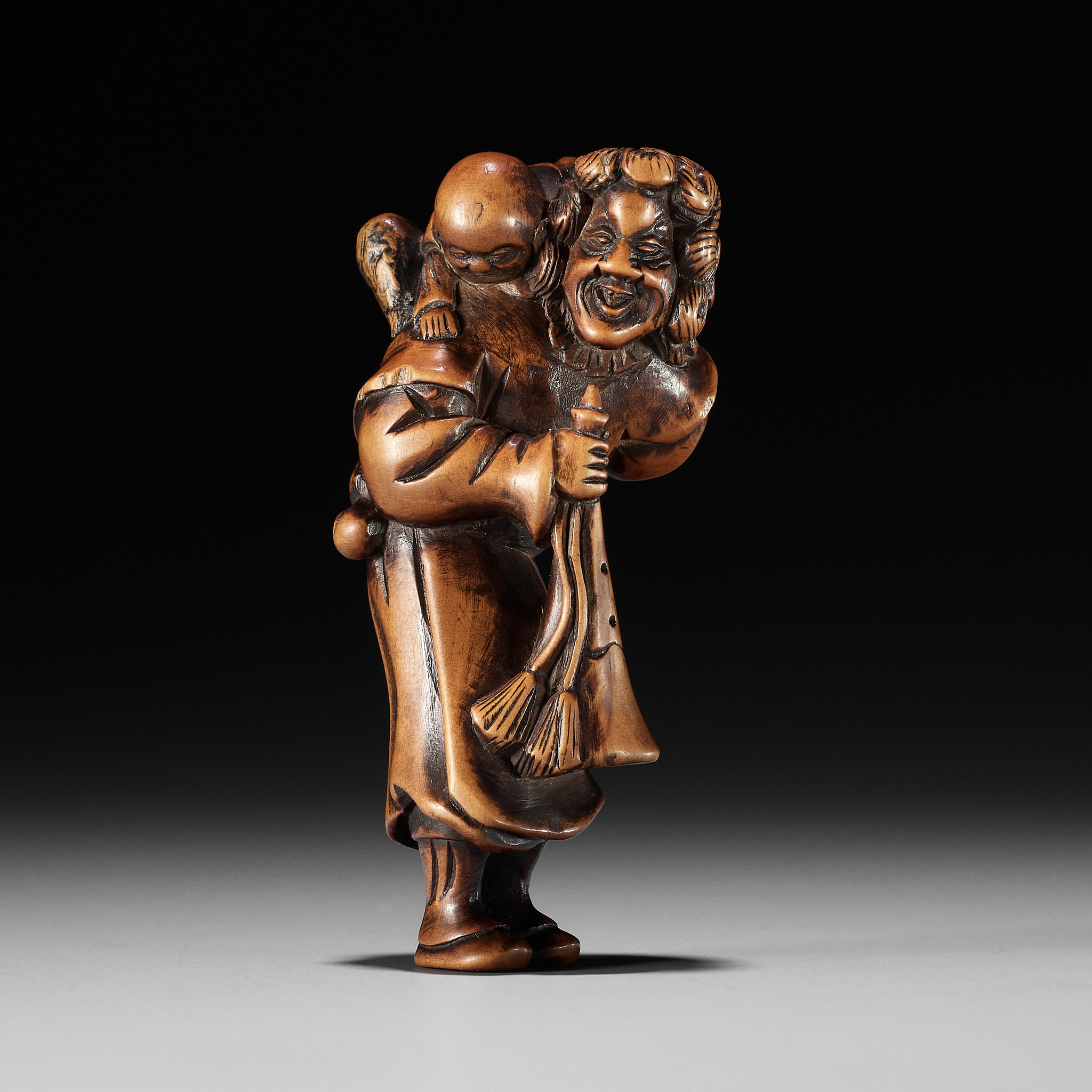 Lot 321 - A WOOD NETSUKE OF A DUTCHMAN WITH CHILD