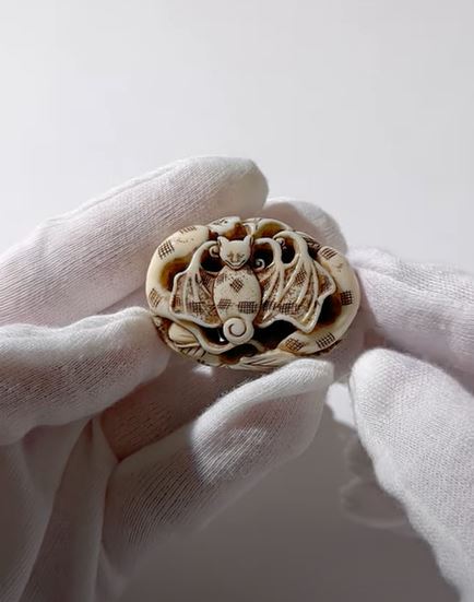 Lot 397 - A WALRUS TUSK RYUSA MANJU NETSUKE DEPICTING