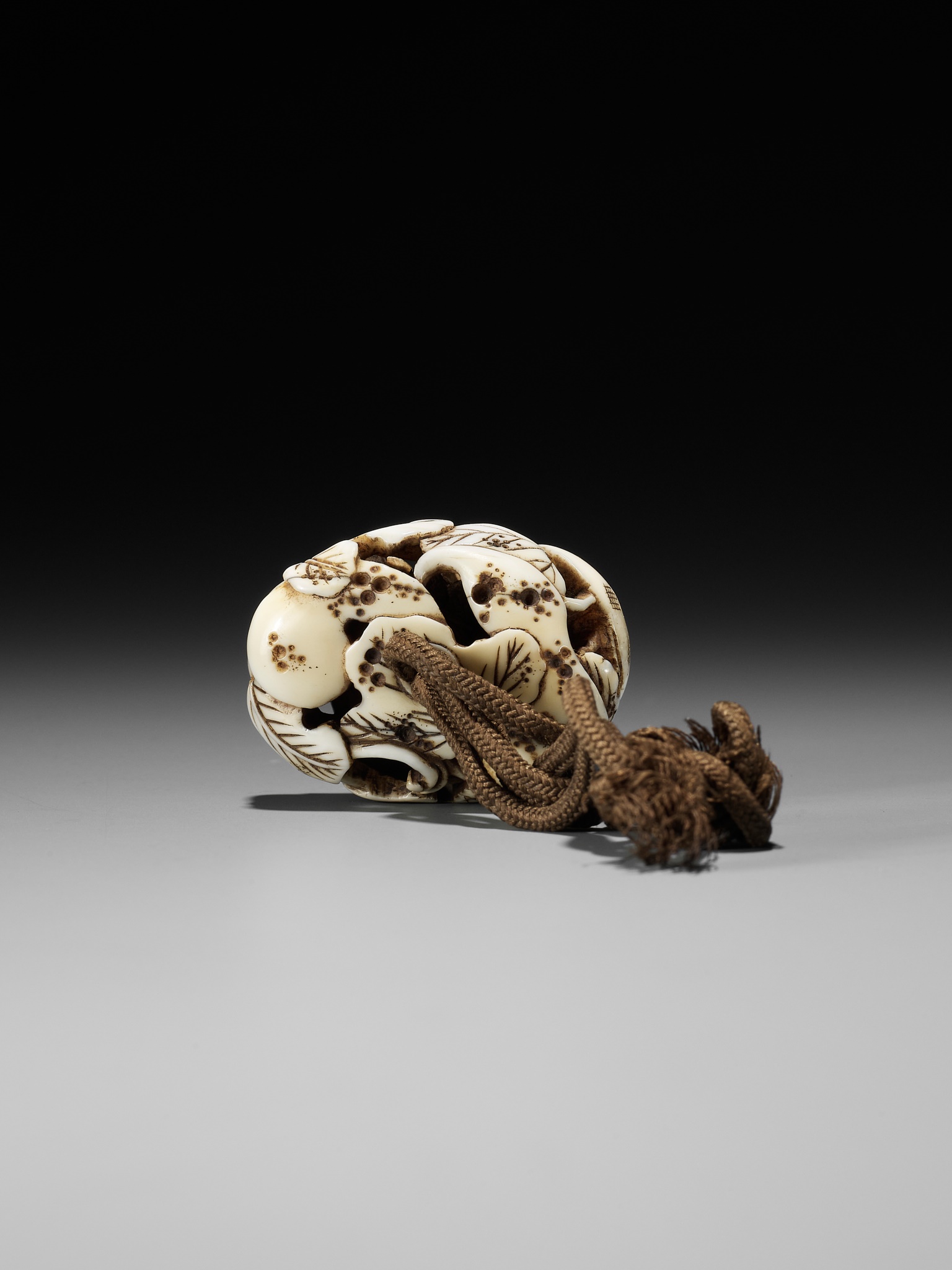 Lot 397 - A WALRUS TUSK RYUSA MANJU NETSUKE DEPICTING