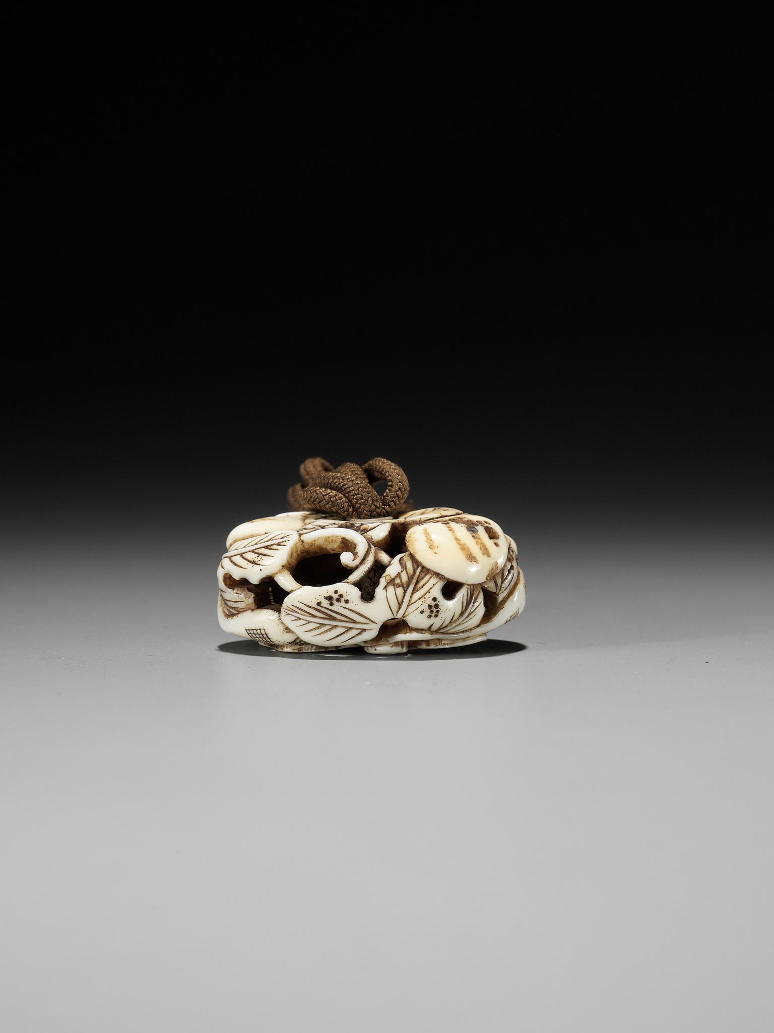 Lot 397 - A WALRUS TUSK RYUSA MANJU NETSUKE DEPICTING