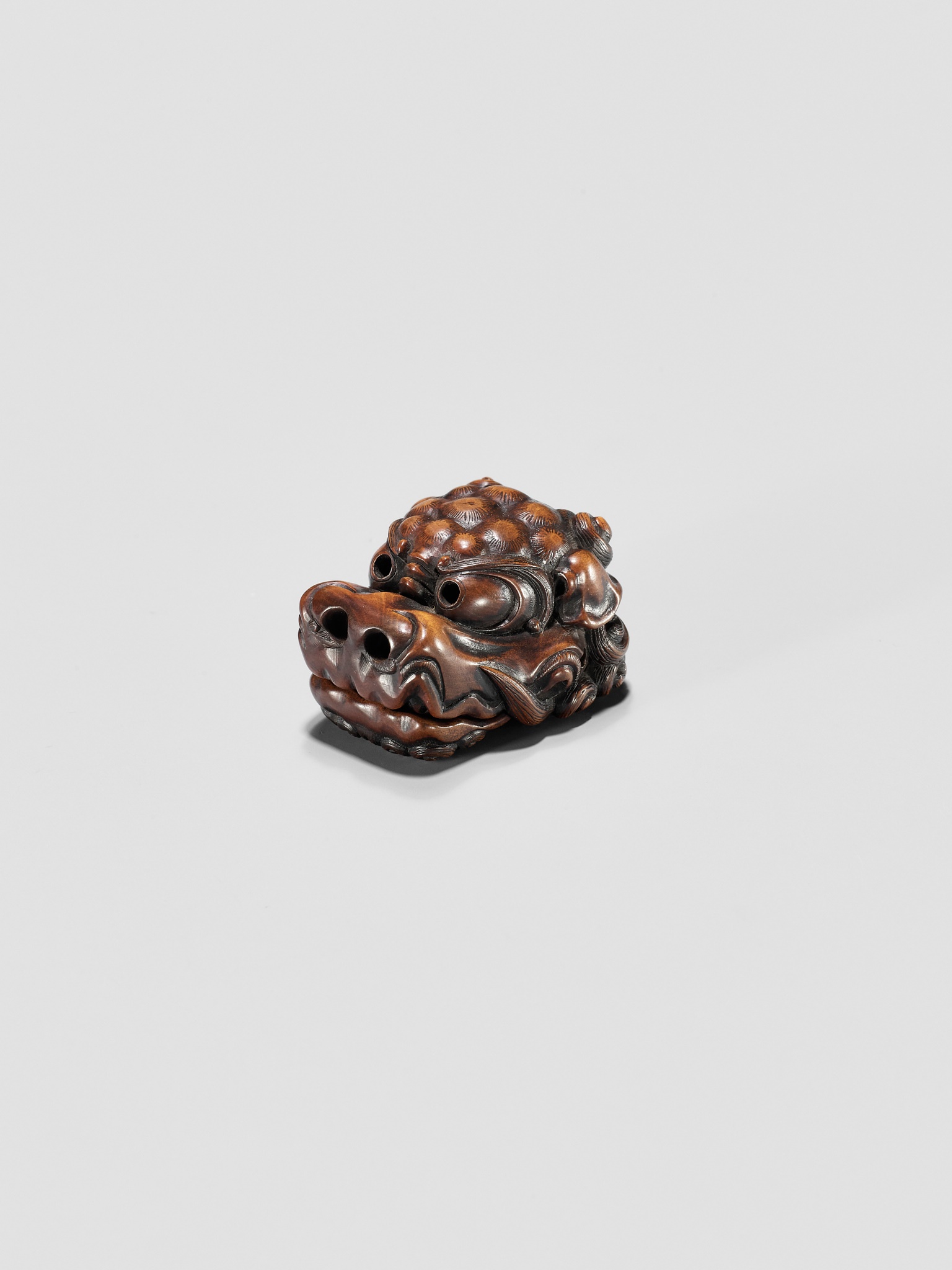 Lot 433 - A WOOD NETSUKE OF A SHISHI MASK WITH MOVABLE