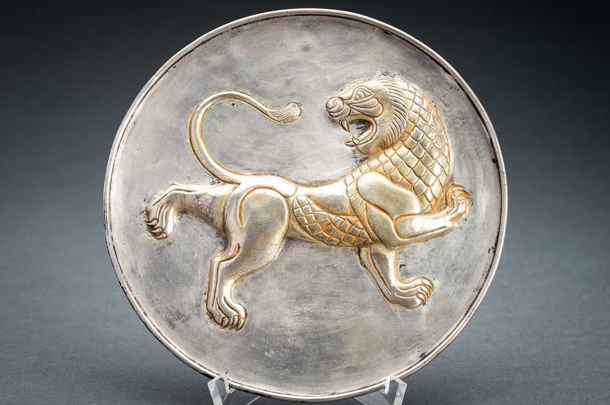 Lot 780 - A PERSIAN PARCEL-GILT SILVER REPOUSSÉ ‘LION’