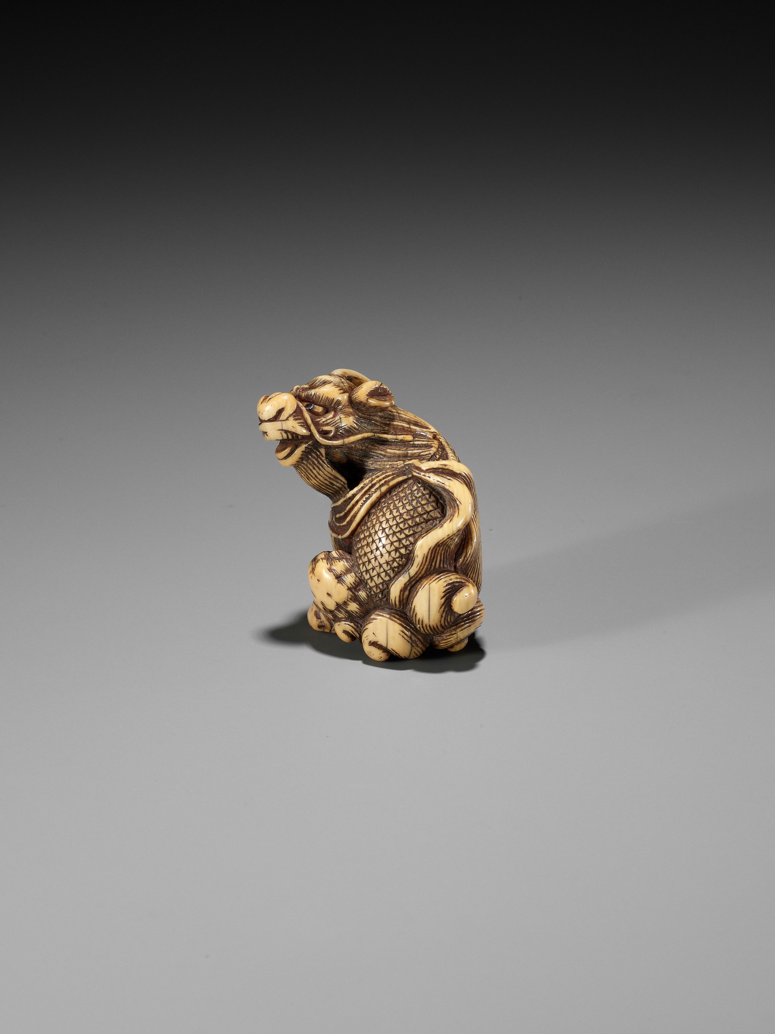 Lot 31 - GYOKUZAN: AN IVORY NETSUKE OF A KIRIN