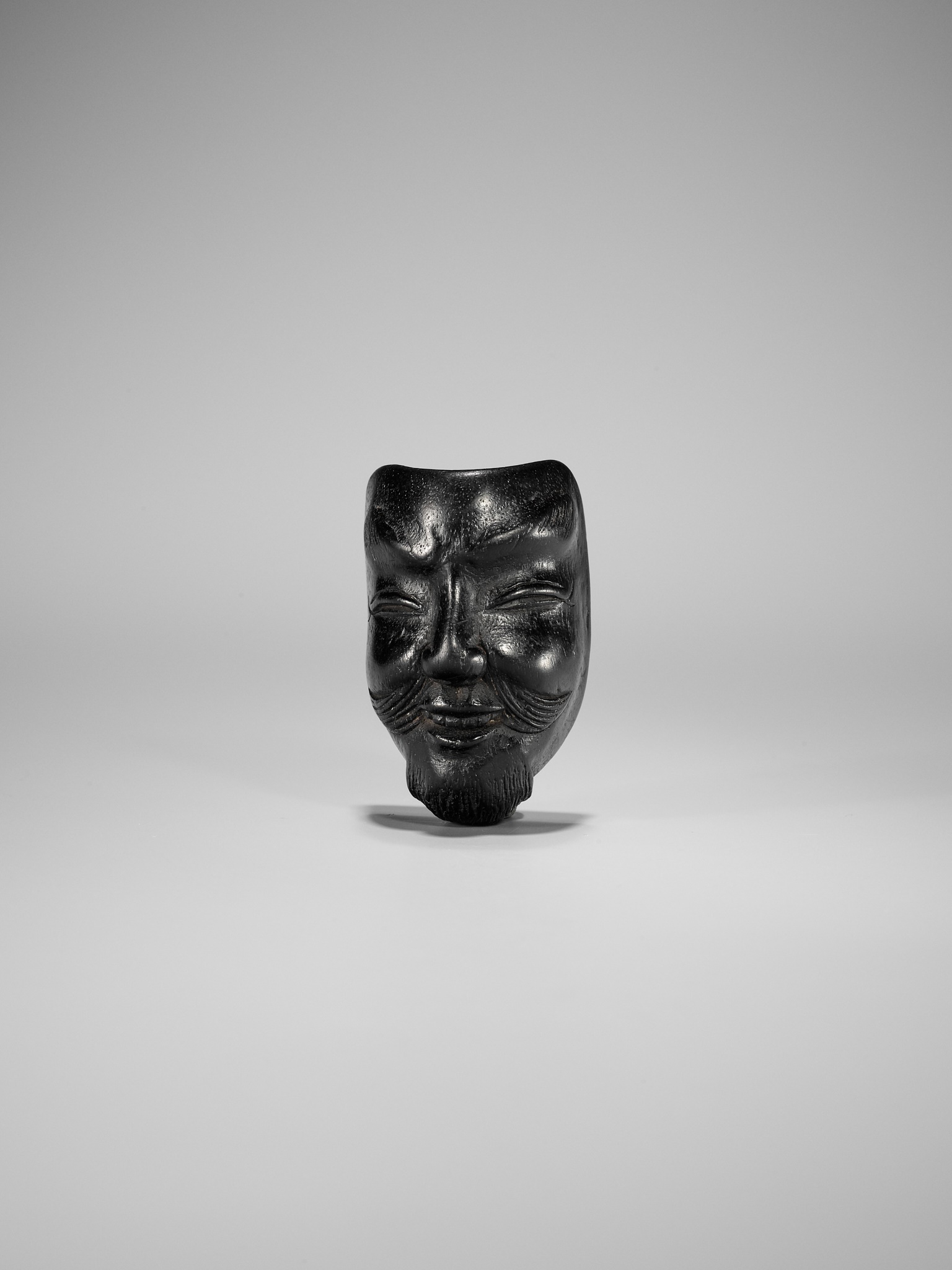 Lot 249 - OKATOMO: A VERY RARE EBONY WOOD MASK NETSUKE