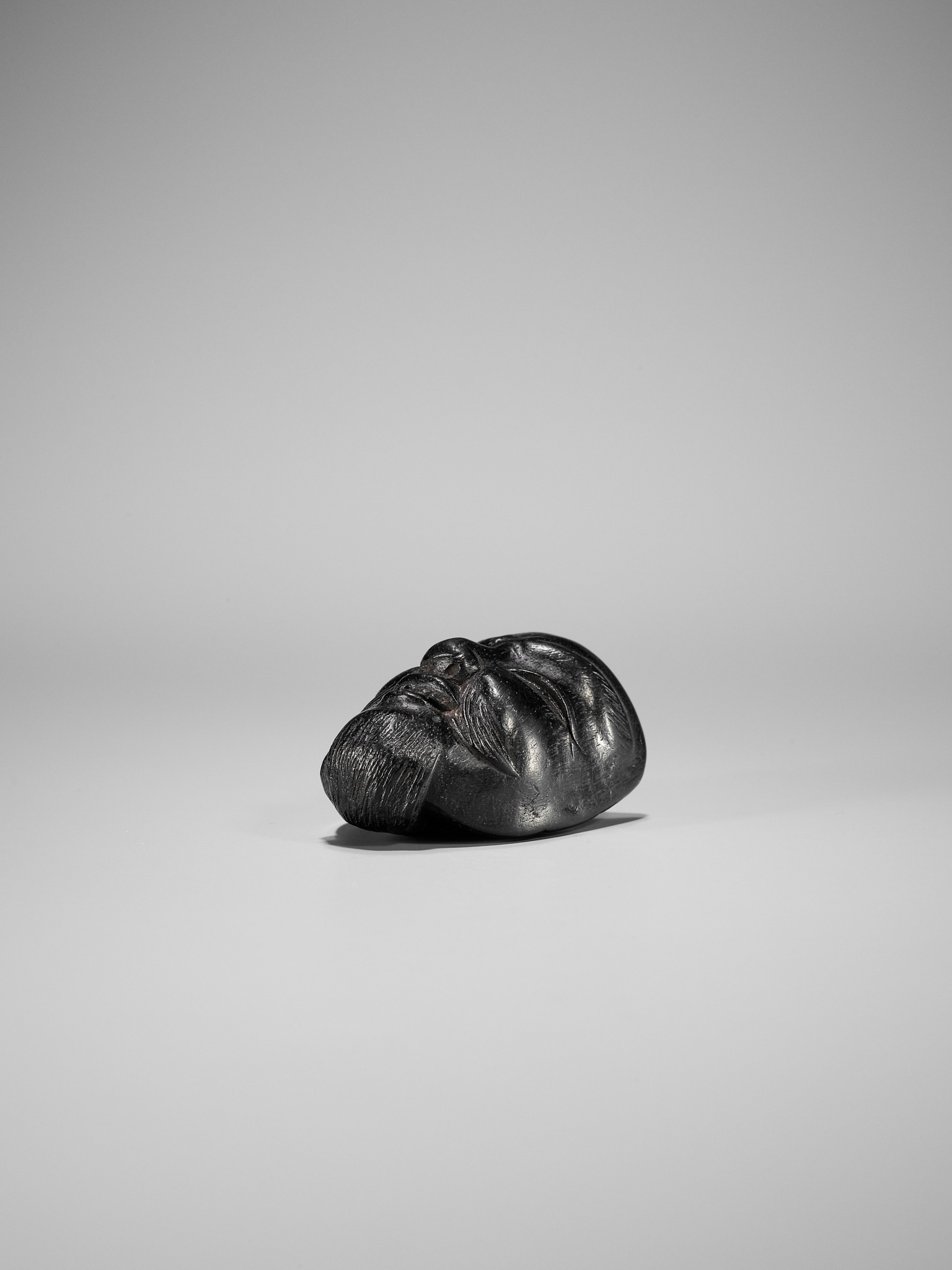 Lot 249 - OKATOMO: A VERY RARE EBONY WOOD MASK NETSUKE