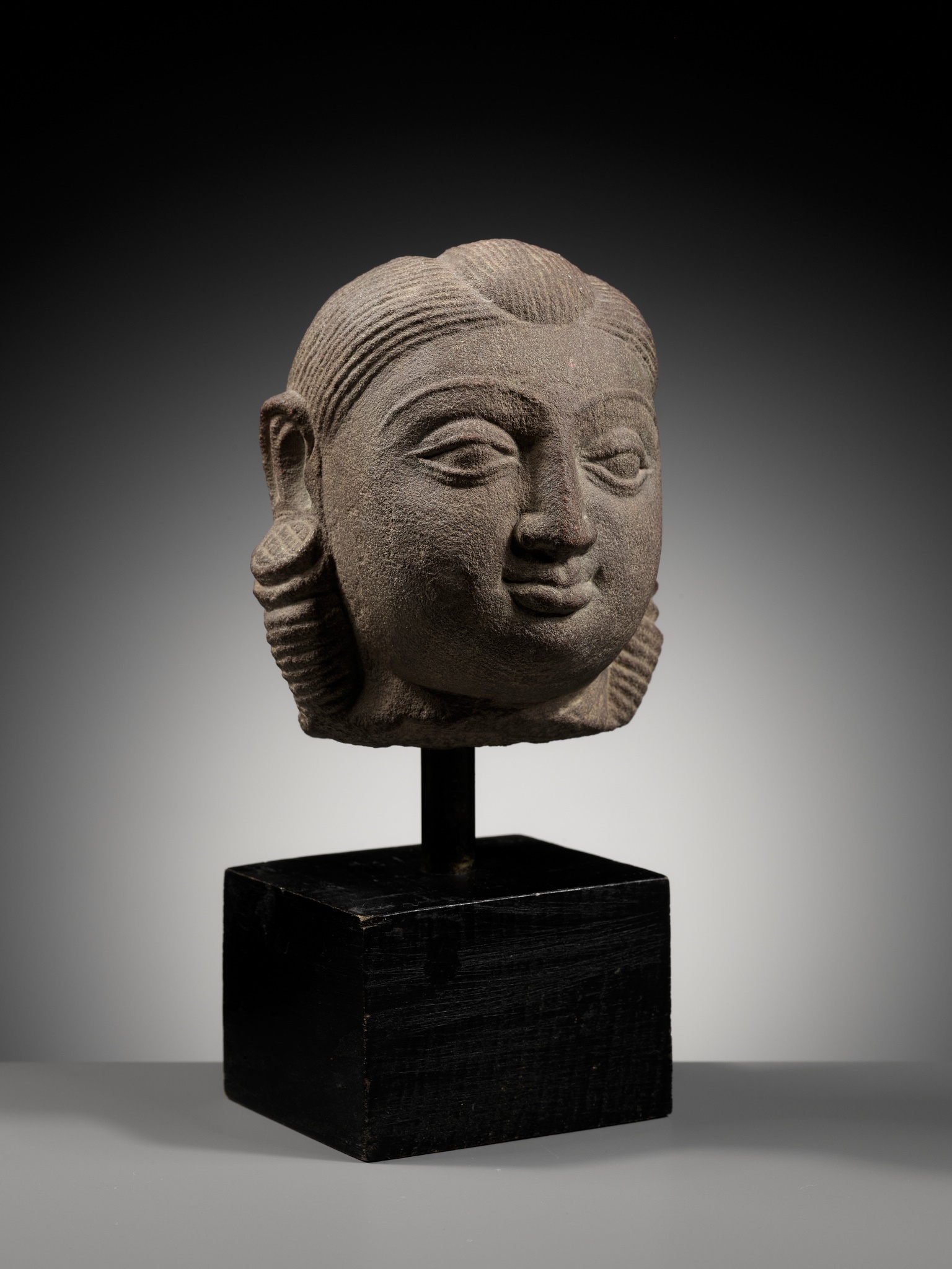 Lot 718 - A PINK SANDSTONE HEAD OF A YAKSHI, MATHURA,