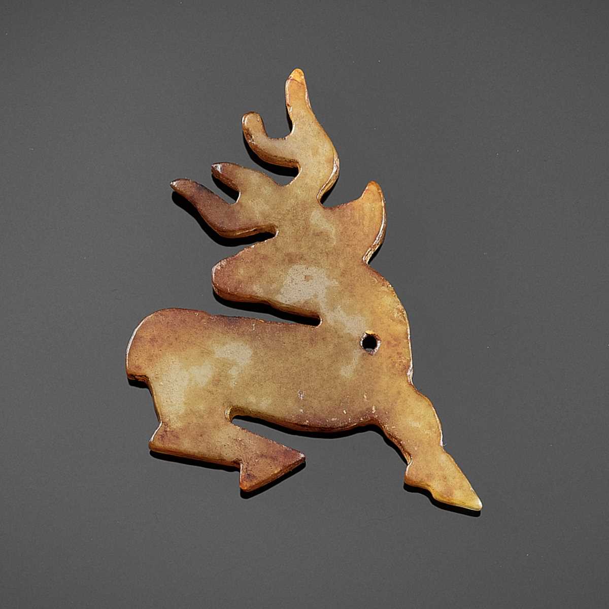 Lot 820 - A CELADON AND RUSSET JADE 'STAG' PENDANT,