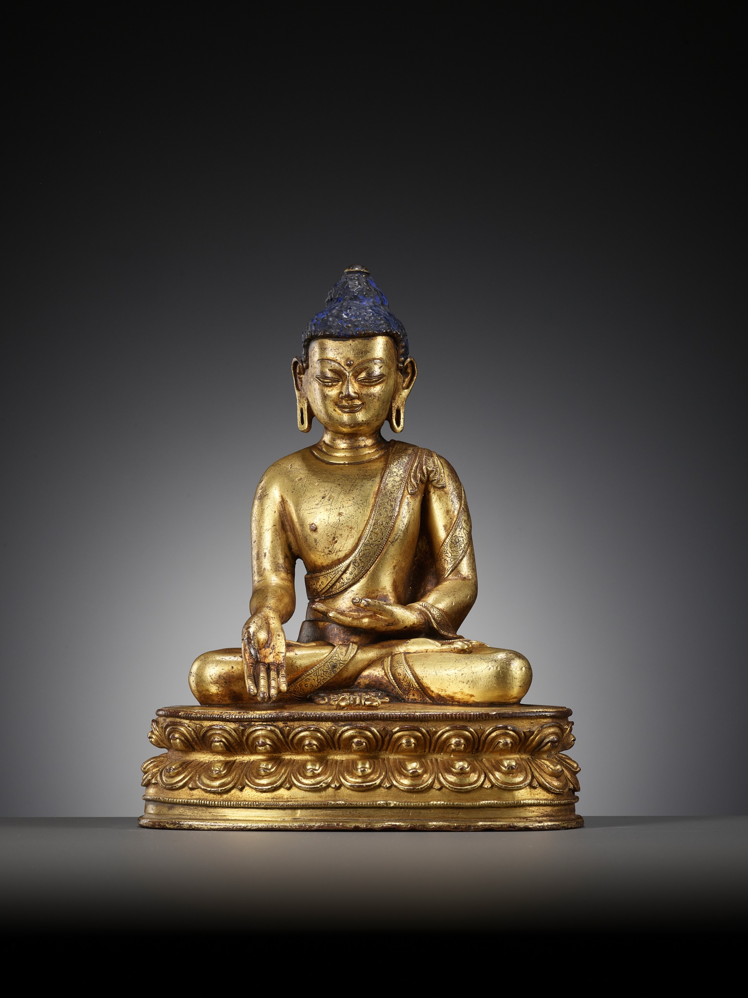 Lot 665 - A GILT BRONZE FIGURE OF THE RATNASAMBHAVA