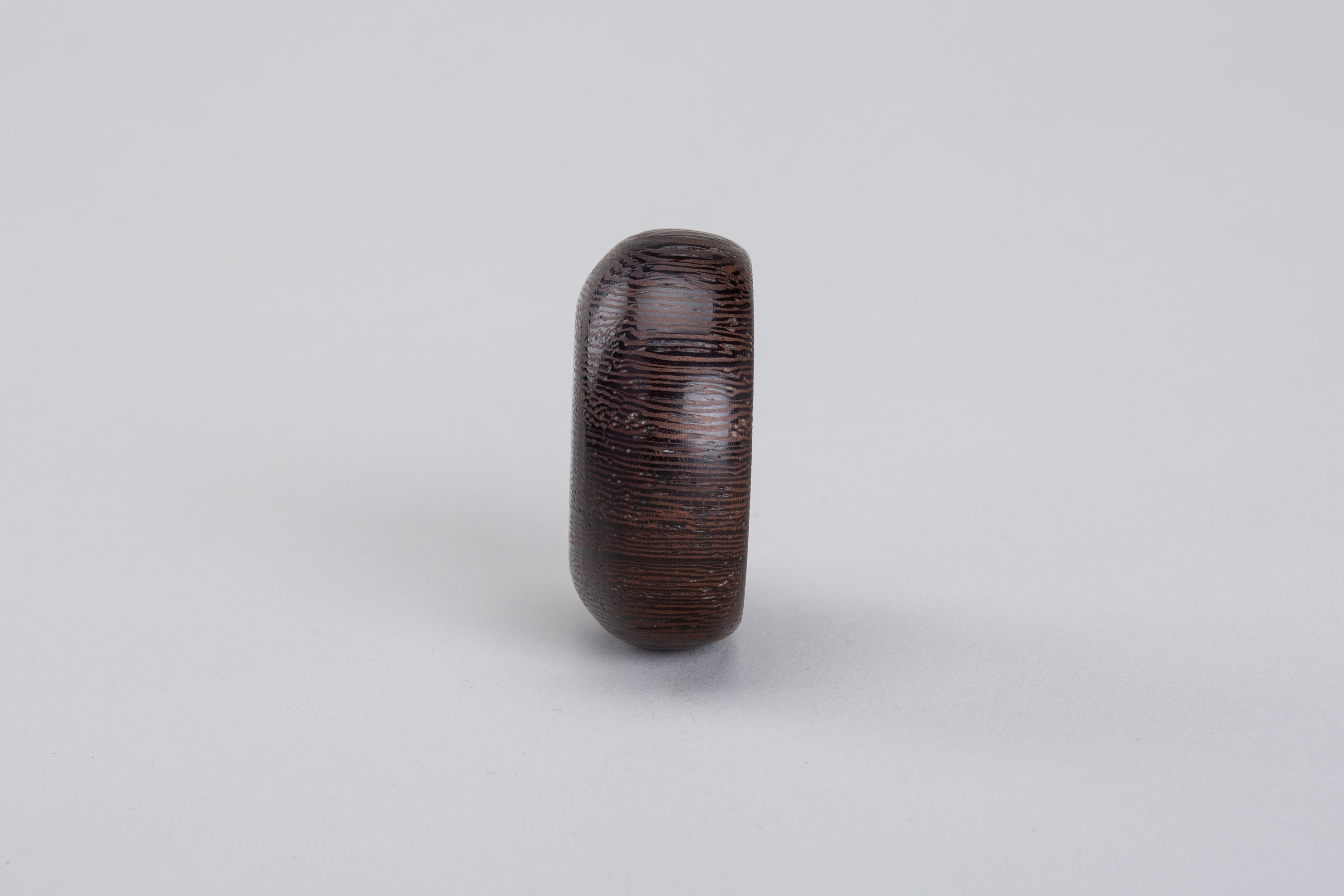 Lot 442 - A WOOD KAGAMIBUTA NETSUKE WITH SHIBUICHI