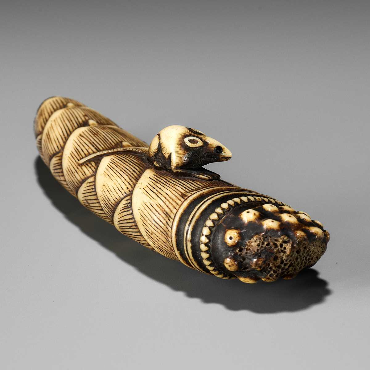 Lot 261 - AN EARLY ANTLER NETSUKE DEPICTING A RAT ON A