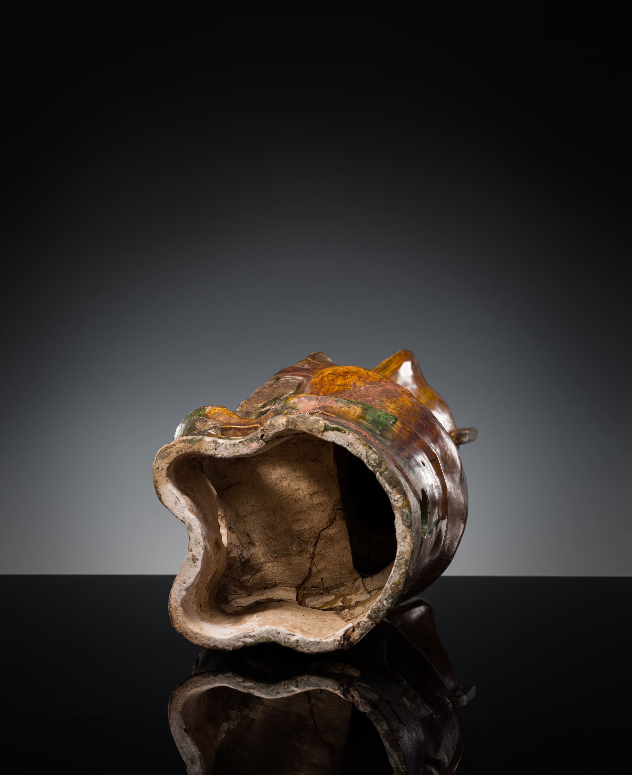 Lot 132 - A SANCAI-GLAZED FIGURE OF A LEONINE EARTH