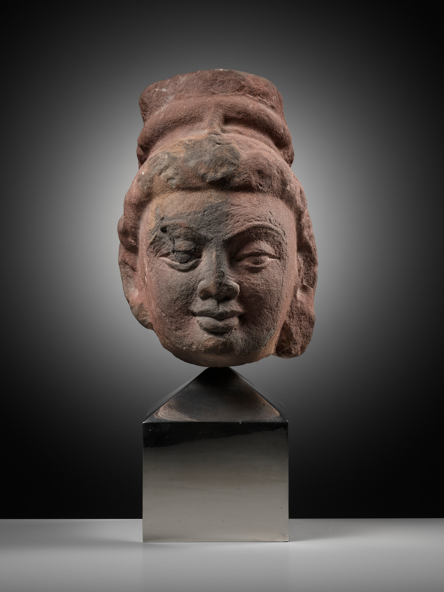 Lot 629 - A RARE MOTTLED RED SANDSTONE HEAD OF A