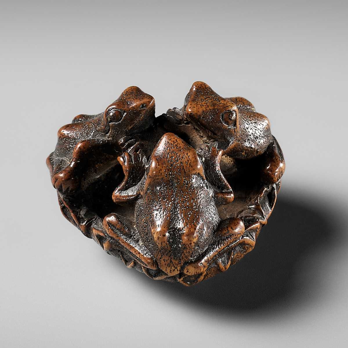 Lot 494 - A FINE WOOD NETSUKE OF THREE FROGS ON A