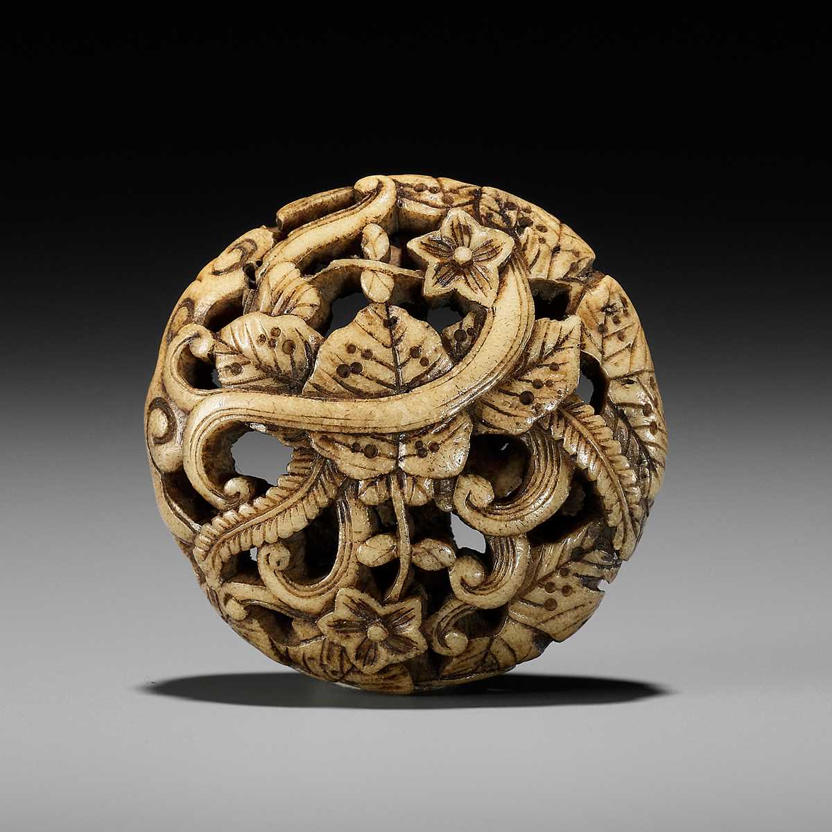 Lot 266 - AN ANTLER RYUSA MANJU NETSUKE WITH FLORAL