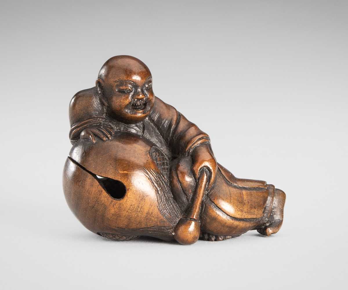 Lot 1599 - A WOOD NETSUKE OF A MONK WITH MOKUGYO