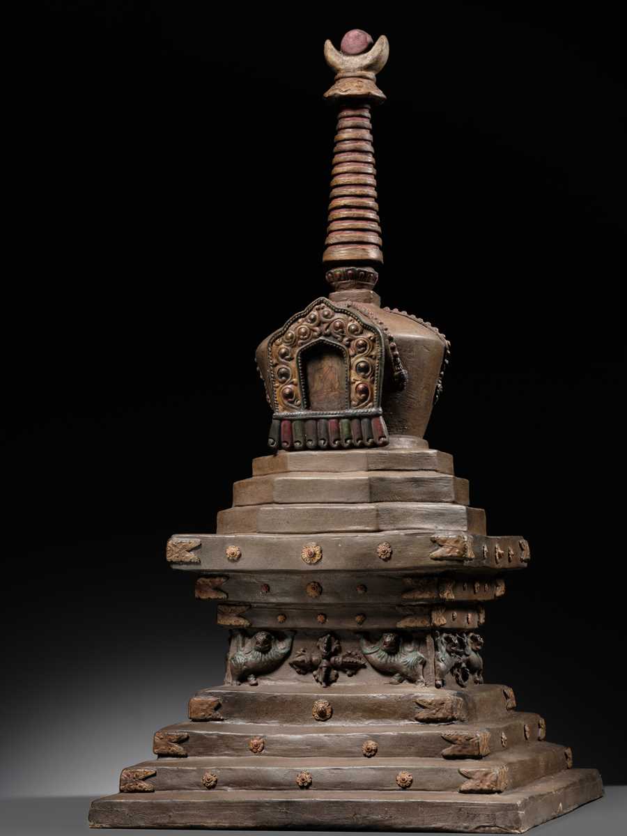 Lot 114 - A VERY LARGE PAINTED CLAY VOTIVE STUPA WITH
