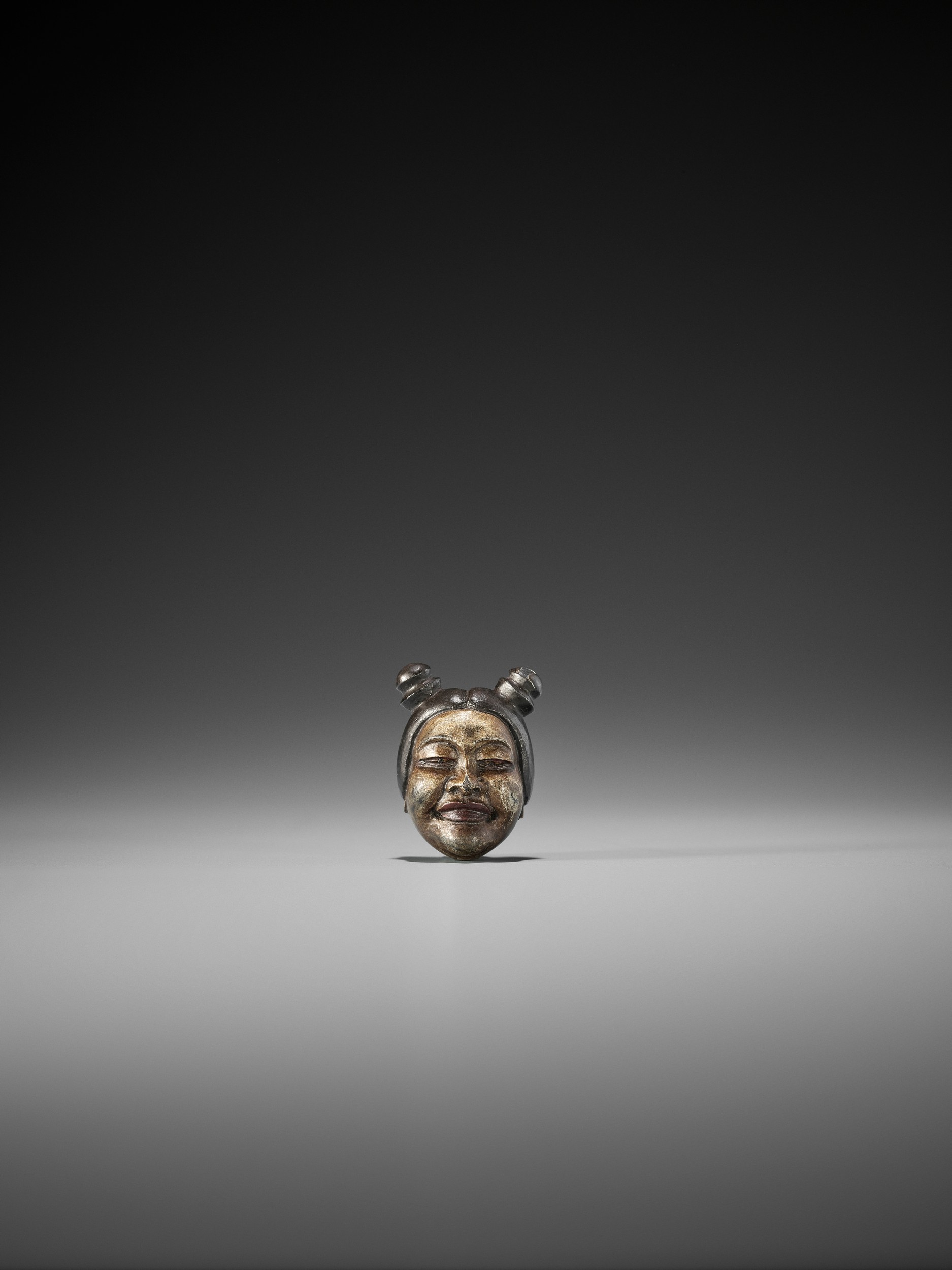 Lot 222 - RYUUN: A RARE PAINTED WOOD MASK NETSUKE OF