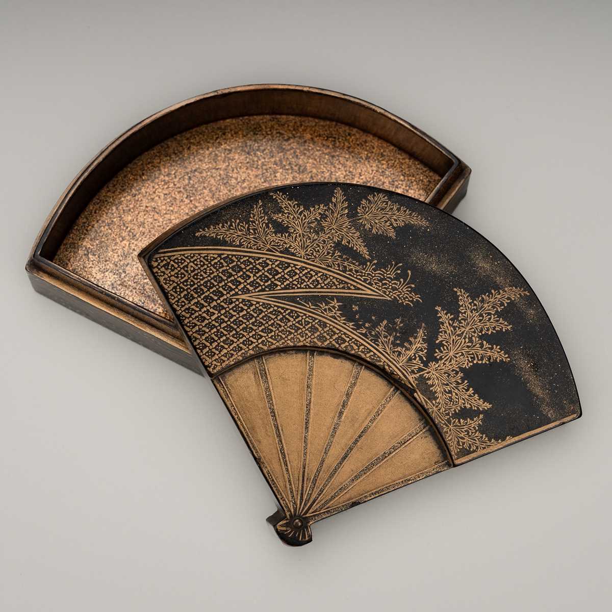 Lot 100 - A BLACK AND GOLD LACQUER FAN-SHAPED KOGO