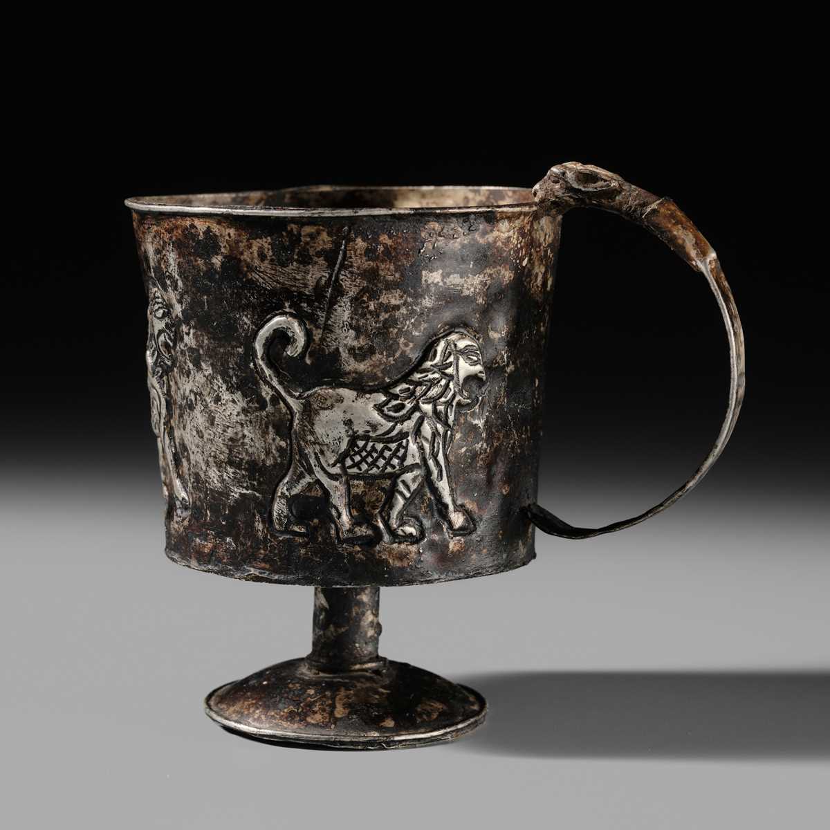 Lot 561 - A PERSIAN SILVER REPOUSSÉ ‘LION’ CUP, IRAN,