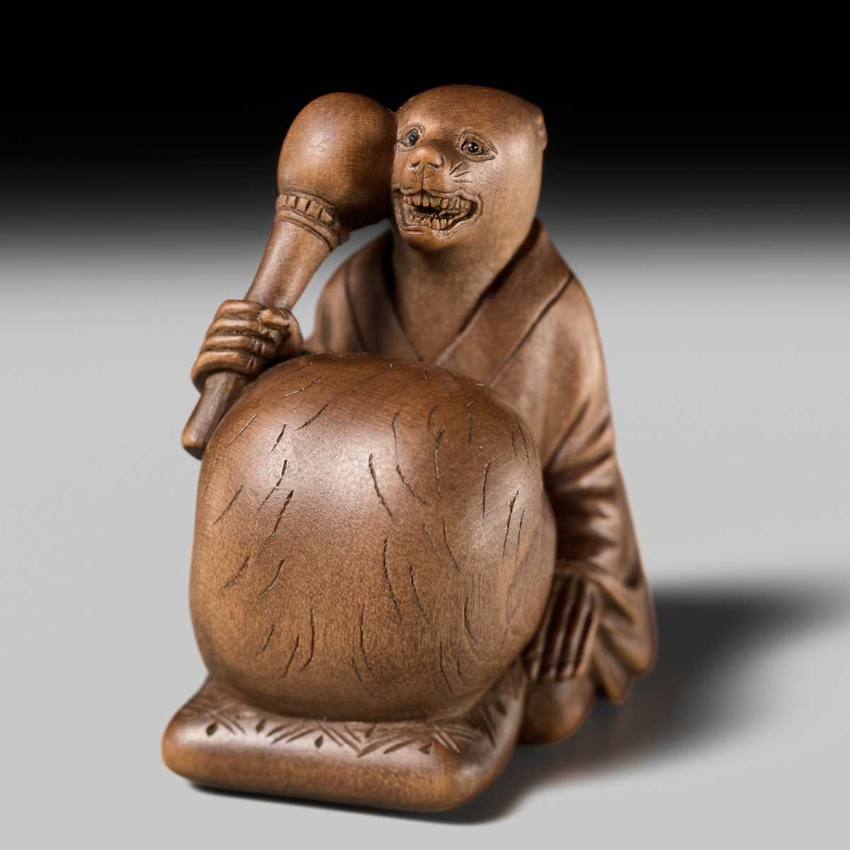 Lot 233 - SUKETADA: AN AMUSING WOOD NETSUKE OF A