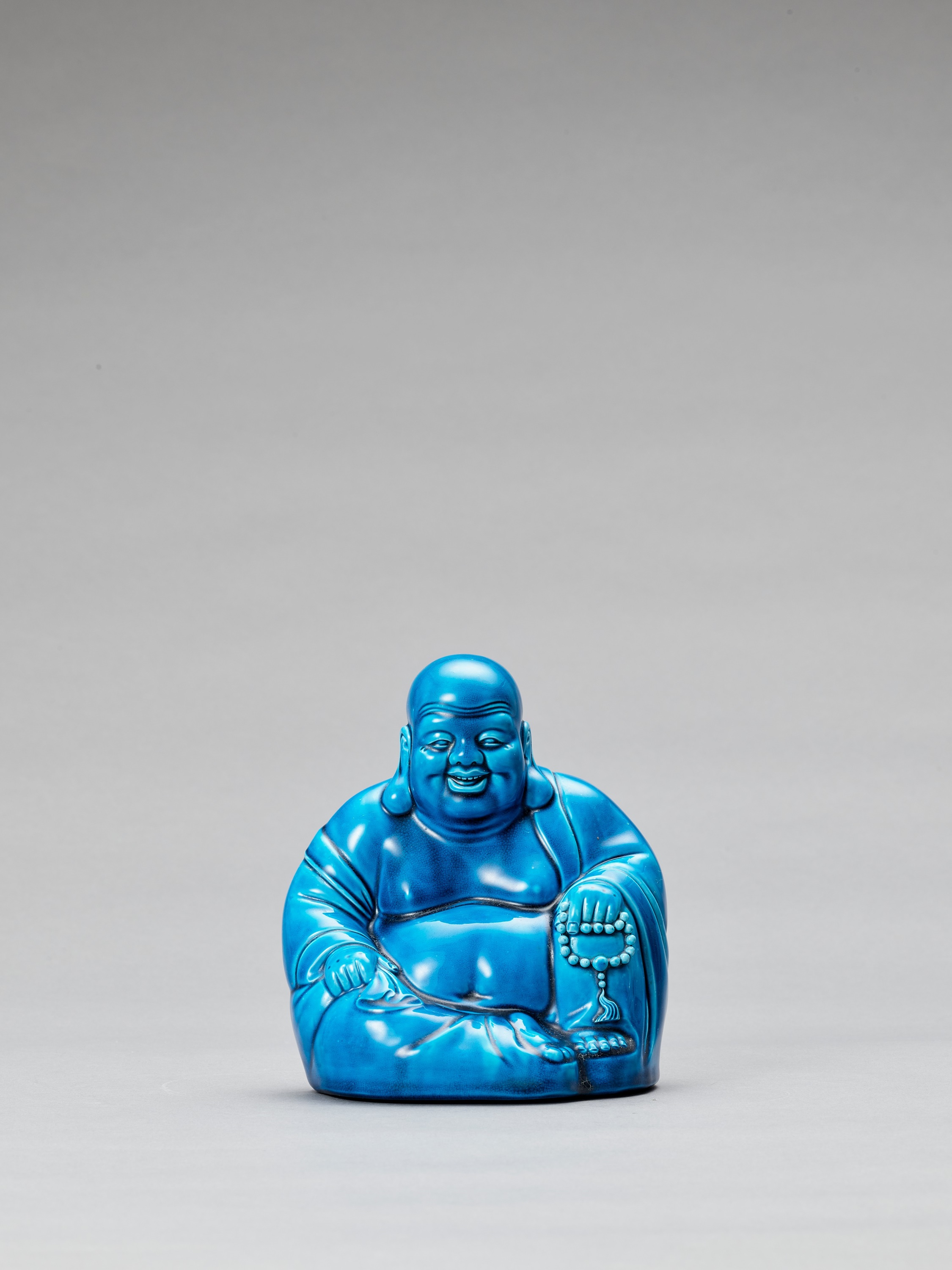 Lot 432 - A TURQUOISE-BLUE GLAZED PORCELAIN BUDAI