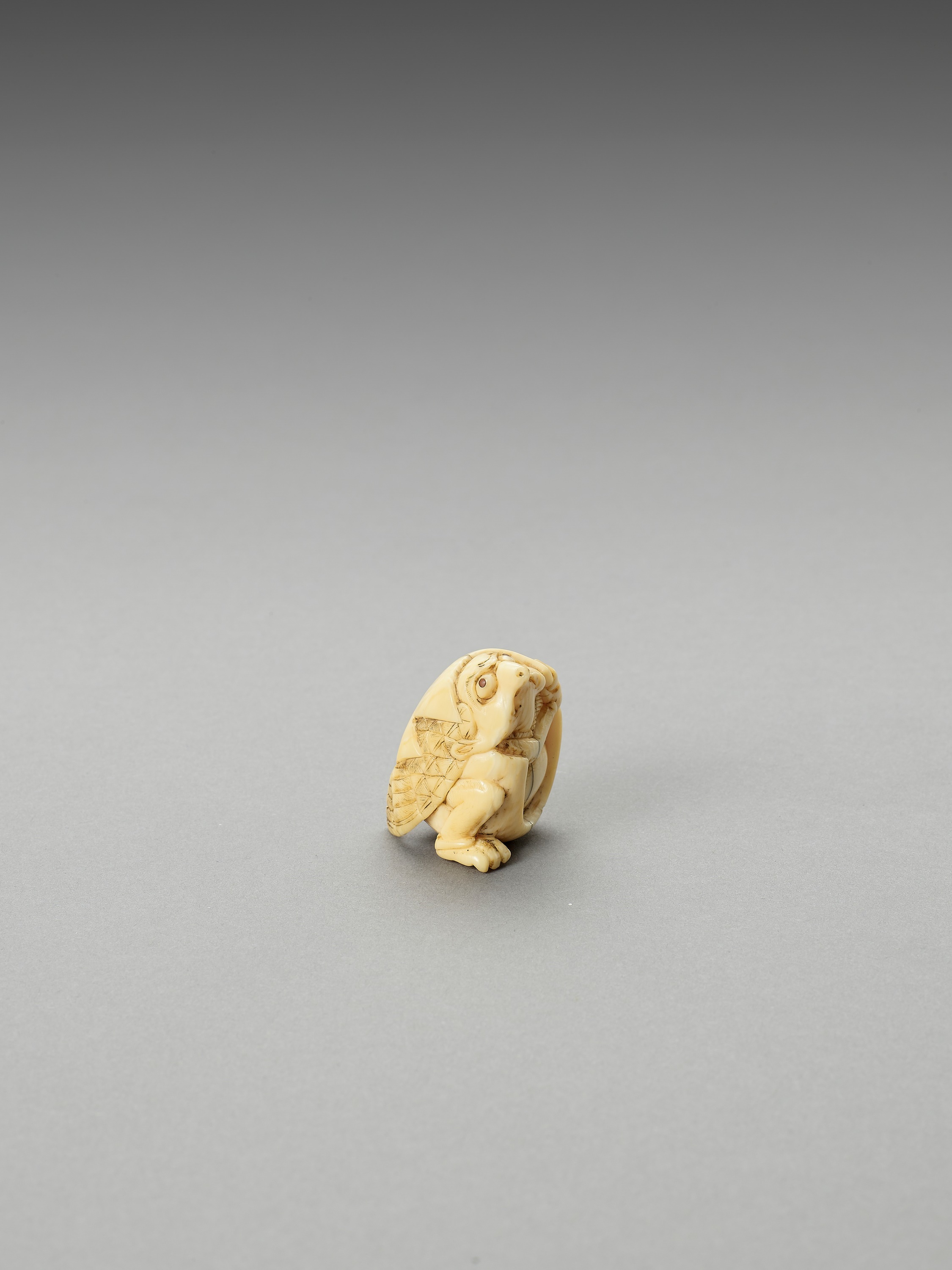 Lot 239 - AN IVORY NETSUKE OF A HATCHING TENGU
