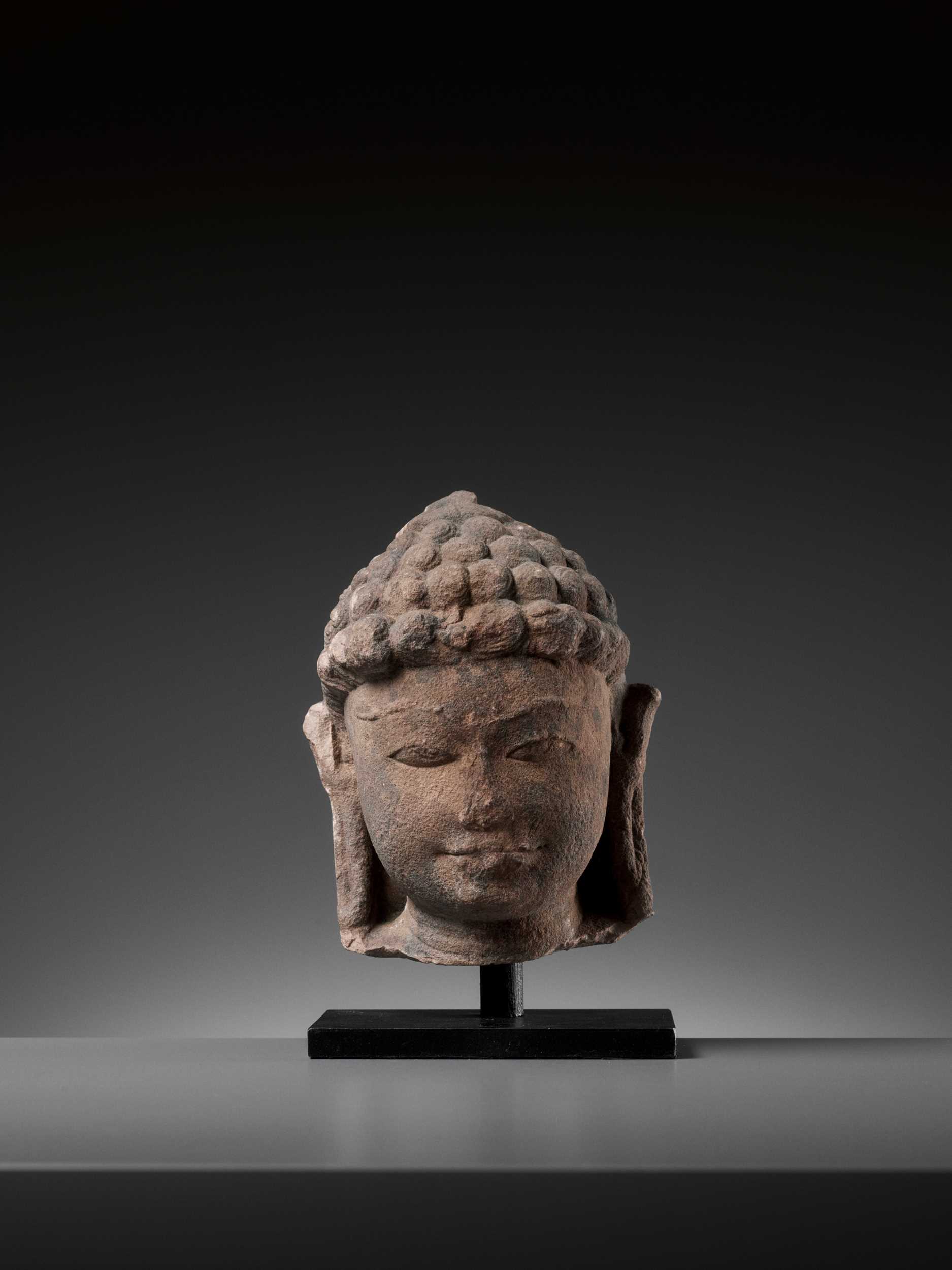 Lot 732 - A JAIN RED SANDSTONE HEAD OF A JINA
