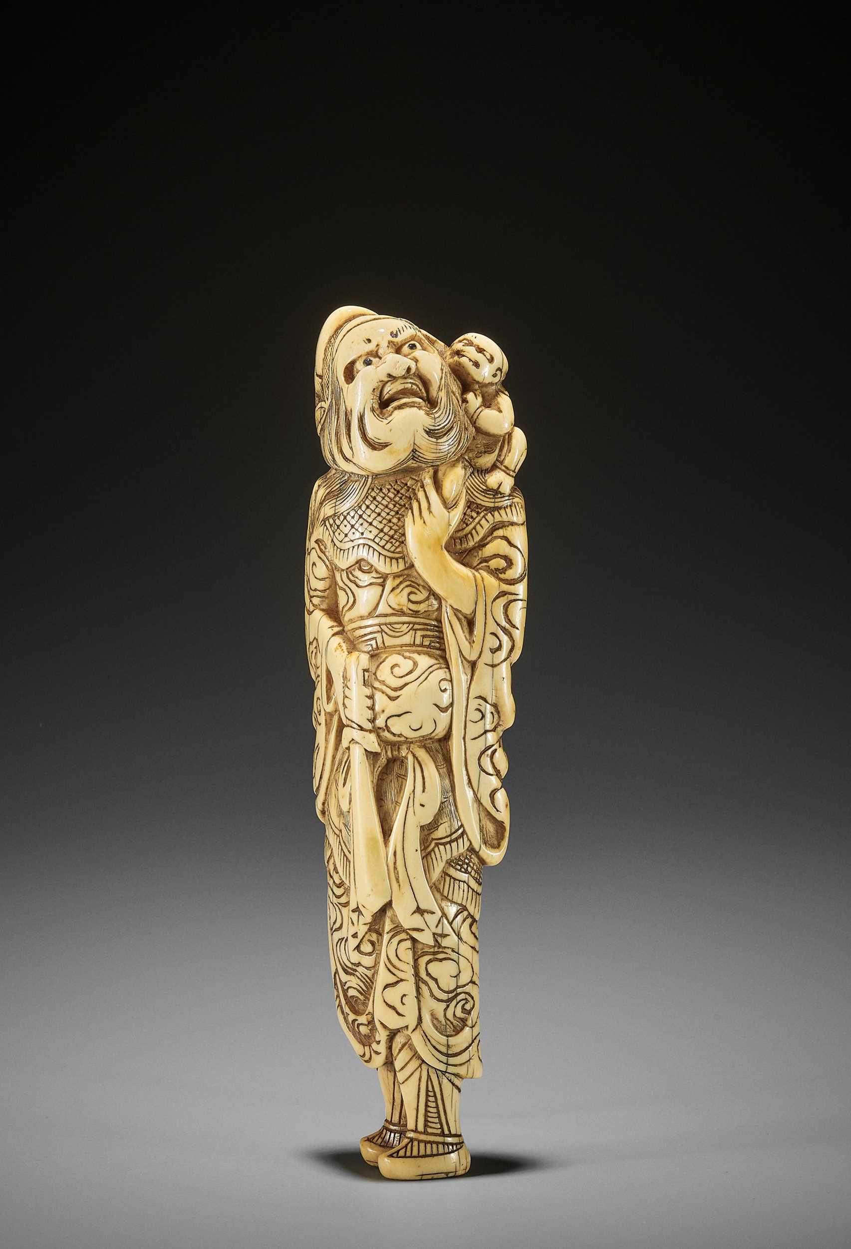 Lot 12 - A MONUMENTALLY TALL IVORY NETSUKE OF SHOKI