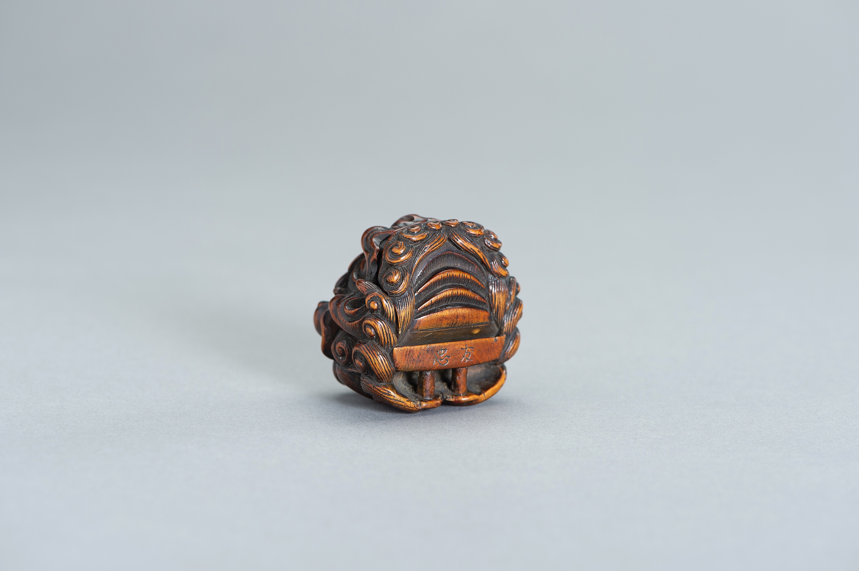 Lot 482 - A POWERFUL WOOD MASK NETSUKE OF A SHISHI