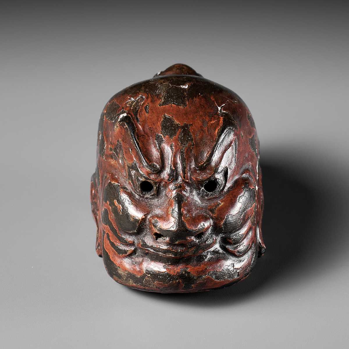 Lot 253 - TESSAI: A LACQUERED WOOD GIGAKU MASK NETSUKE
