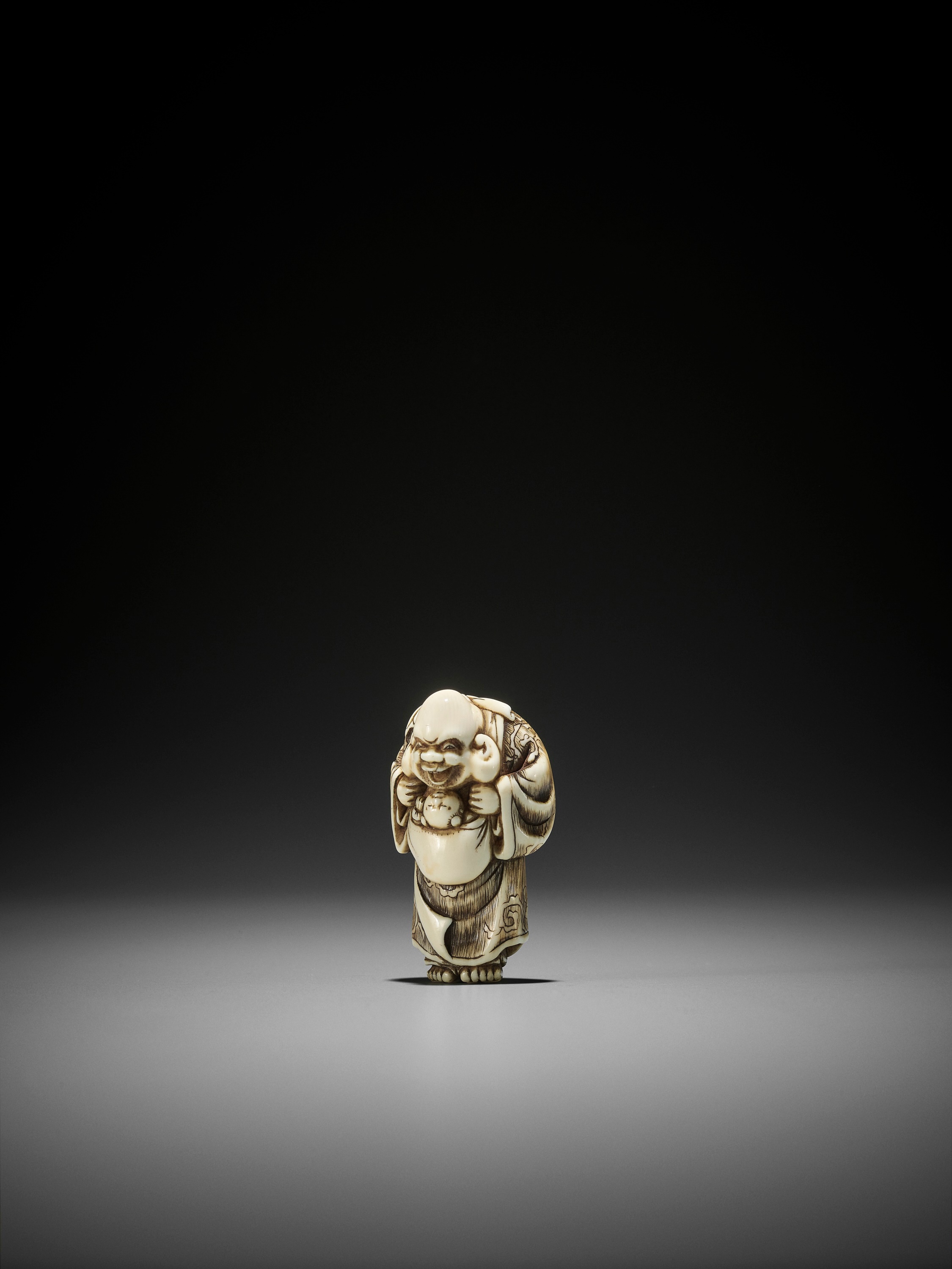 Lot 87 - HIDEMASA: A FINE IVORY NETSUKE OF HOTEI WITH