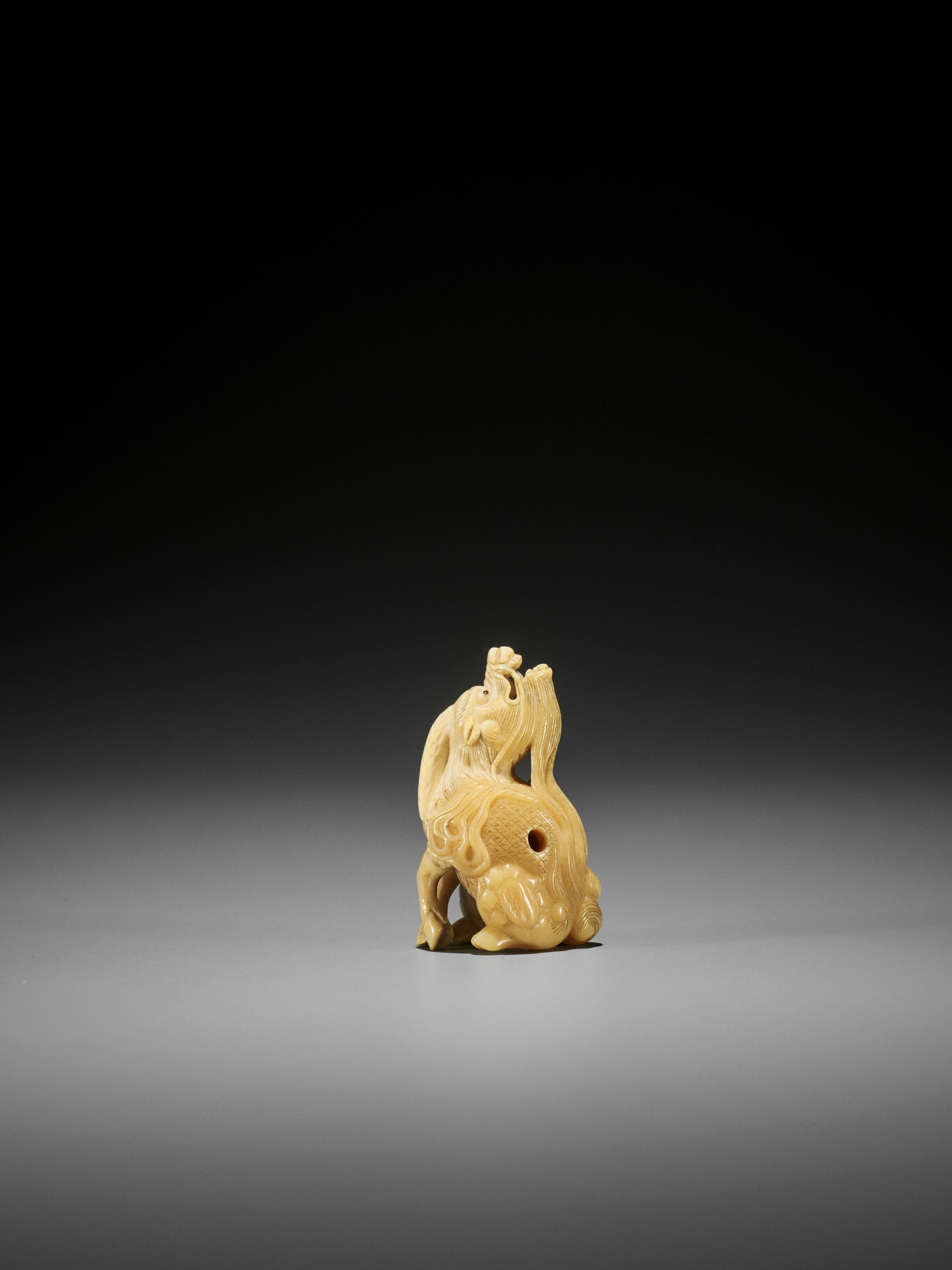 Lot 61 - A RARE NARWHAL TUSK NETSUKE OF A BAYING KIRIN,