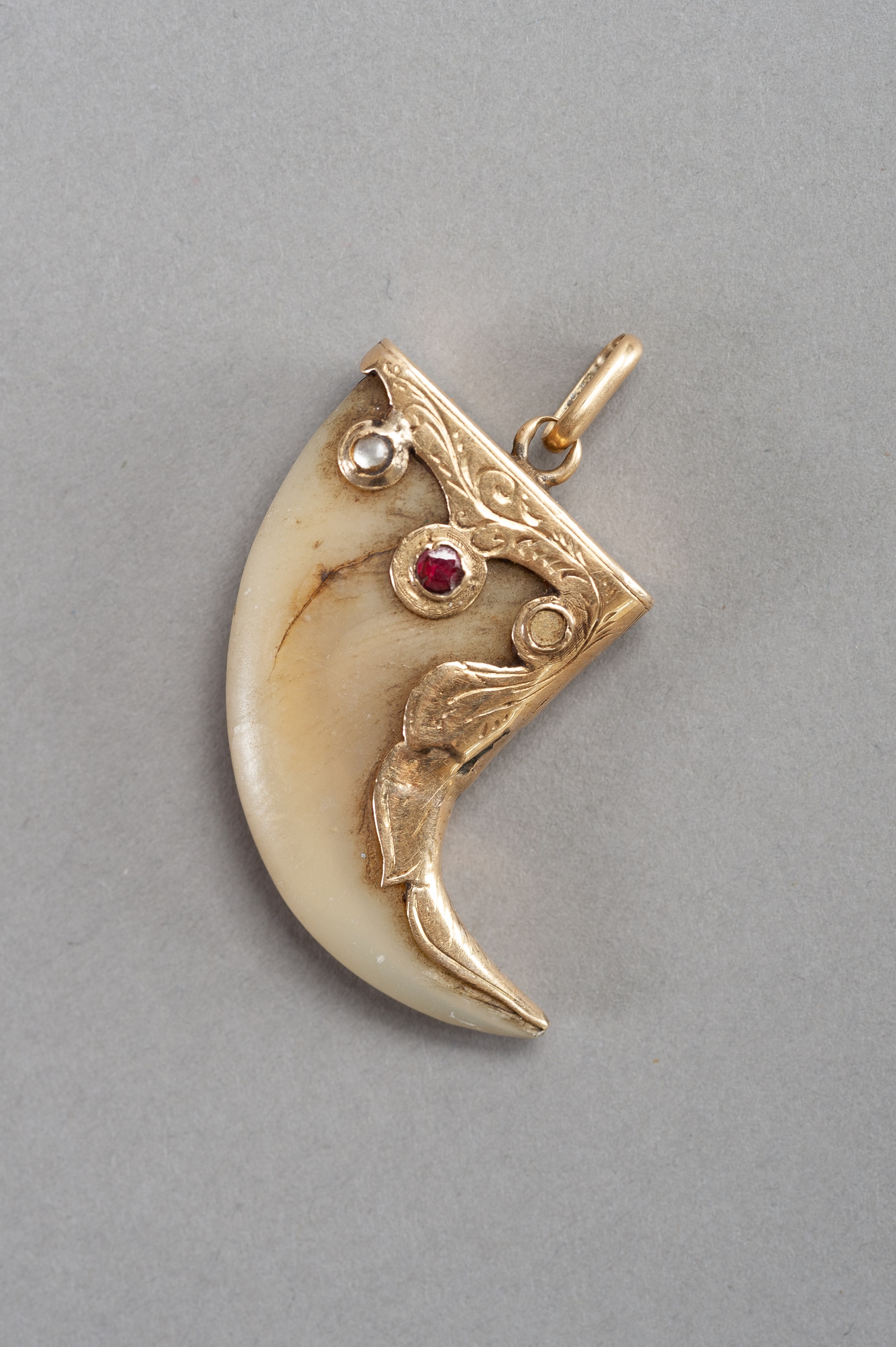 Lot 658 - A GOLD AND GEMSTONE SET TIGER CLAW PENDANT