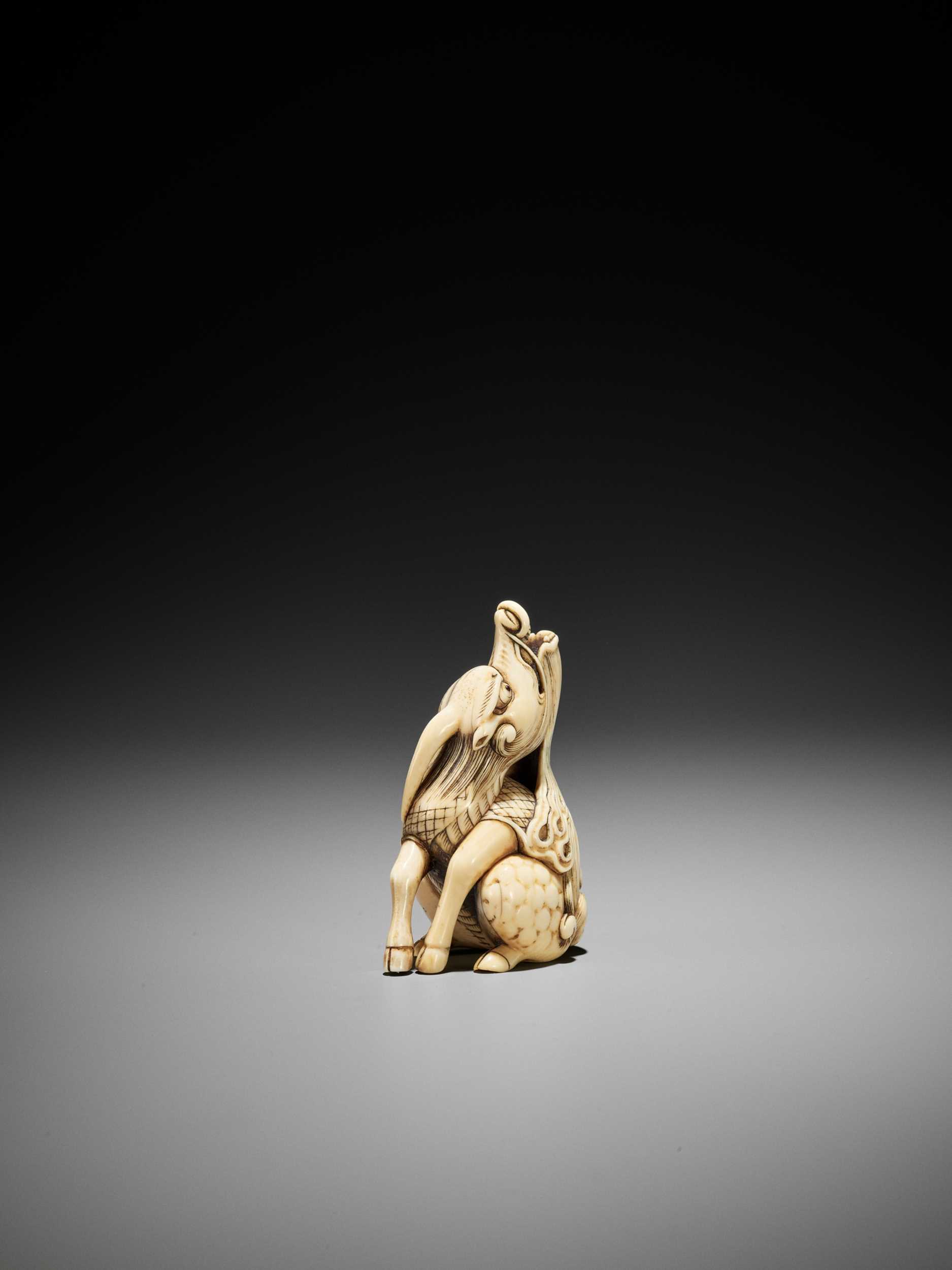 Lot 50 - A POWERFUL IVORY NETSUKE OF A BAYING KIRIN,