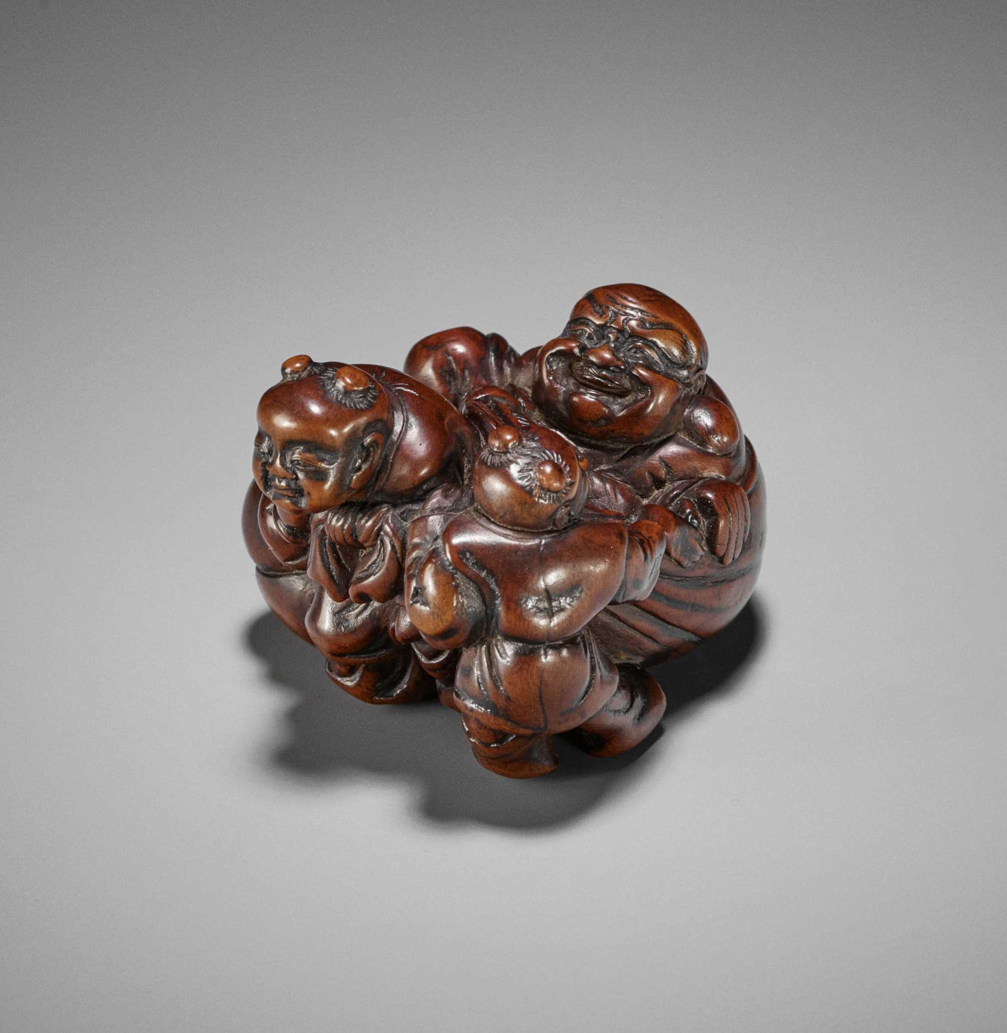 GENRYOSAI MINKOKU: A POWERFUL WOOD NETSUKE OF HOTEI WITH THREE KARAKO ...