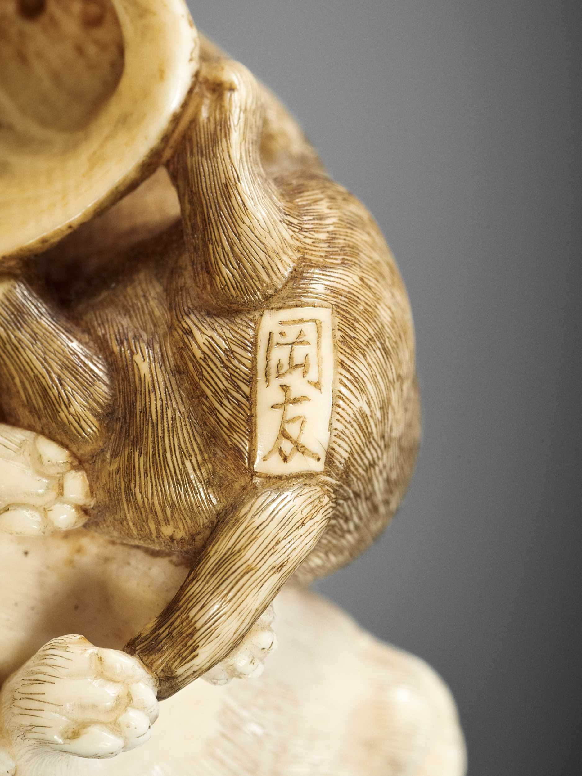 Lot 54 - OKATOMO: AN IVORY NETSUKE OF TWO PUPPIES WITH