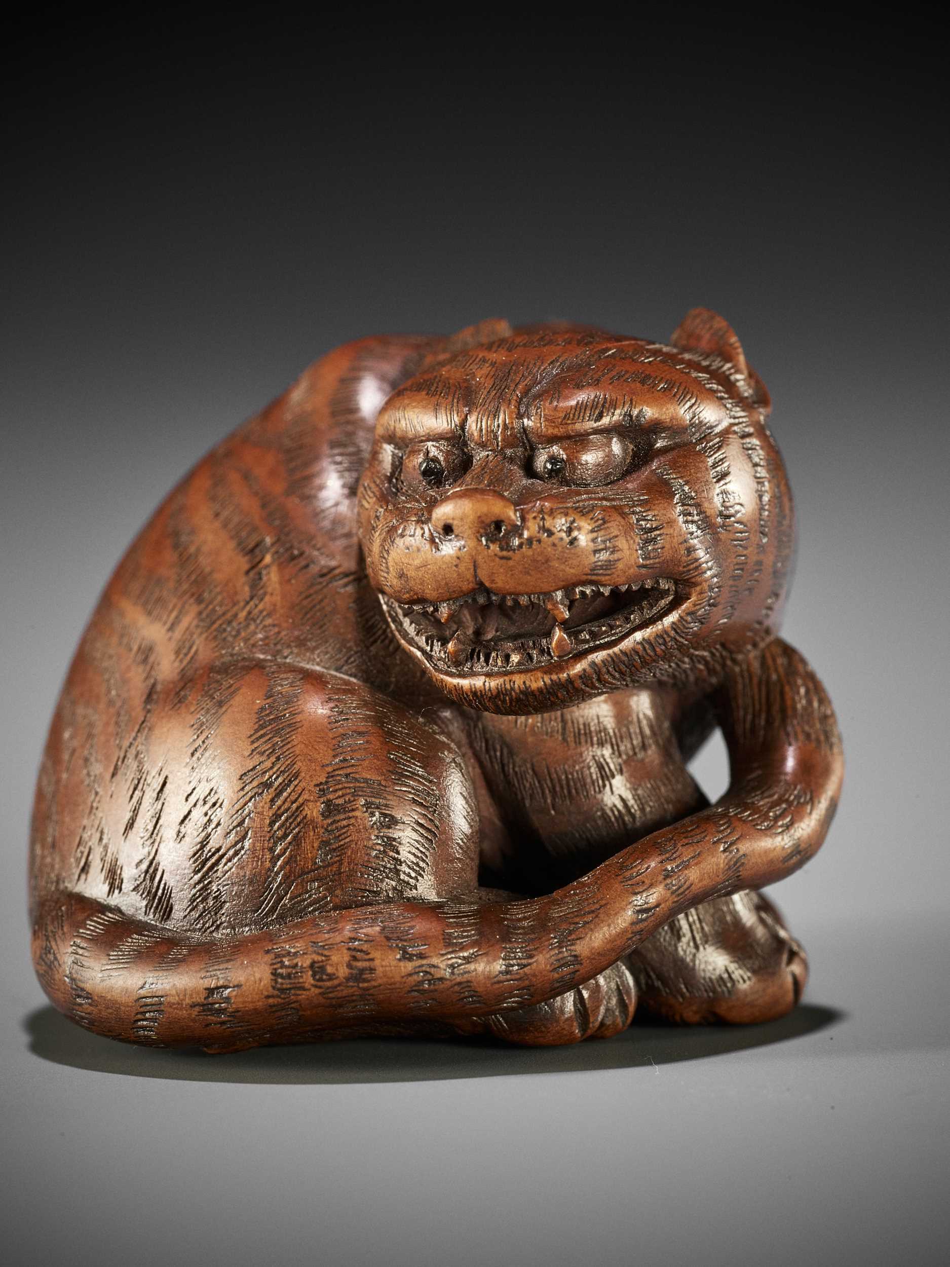 Lot 117 - MASANAO: A SUPERB WOOD NETSUKE OF A TIGER