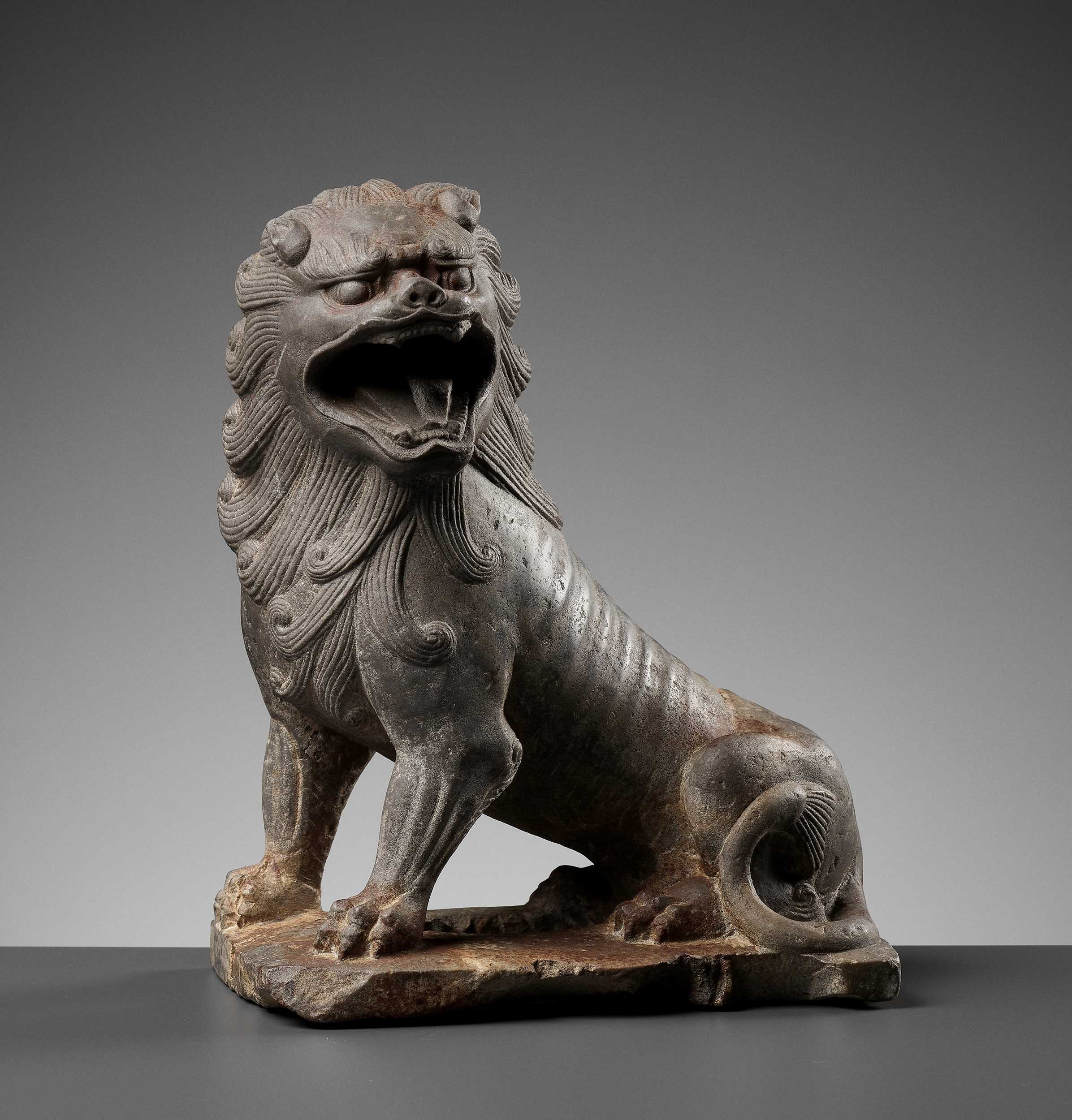 Lot 376 - A SUPERBLY CARVED LIMESTONE FIGURE OF A LION,