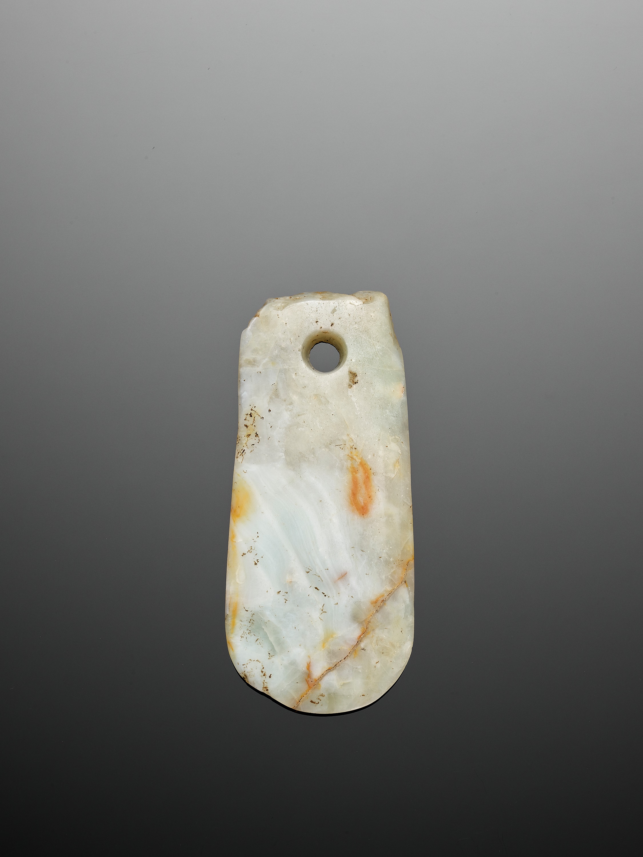 Lot 142 - A CELADON AND RUSSET JADE AXE, NEOLITHIC